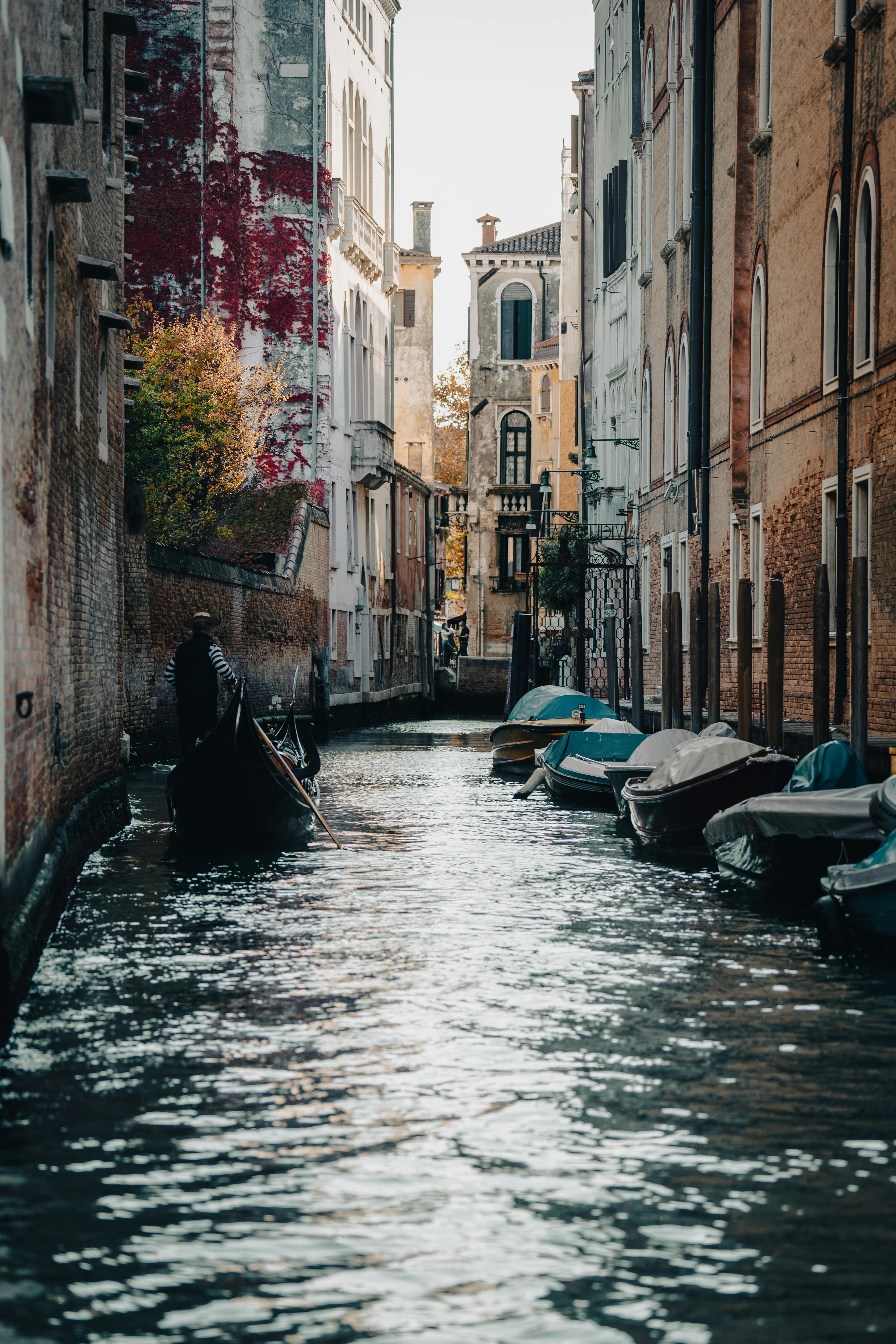 Boat on River Between Buildings · Free Stock Photo
