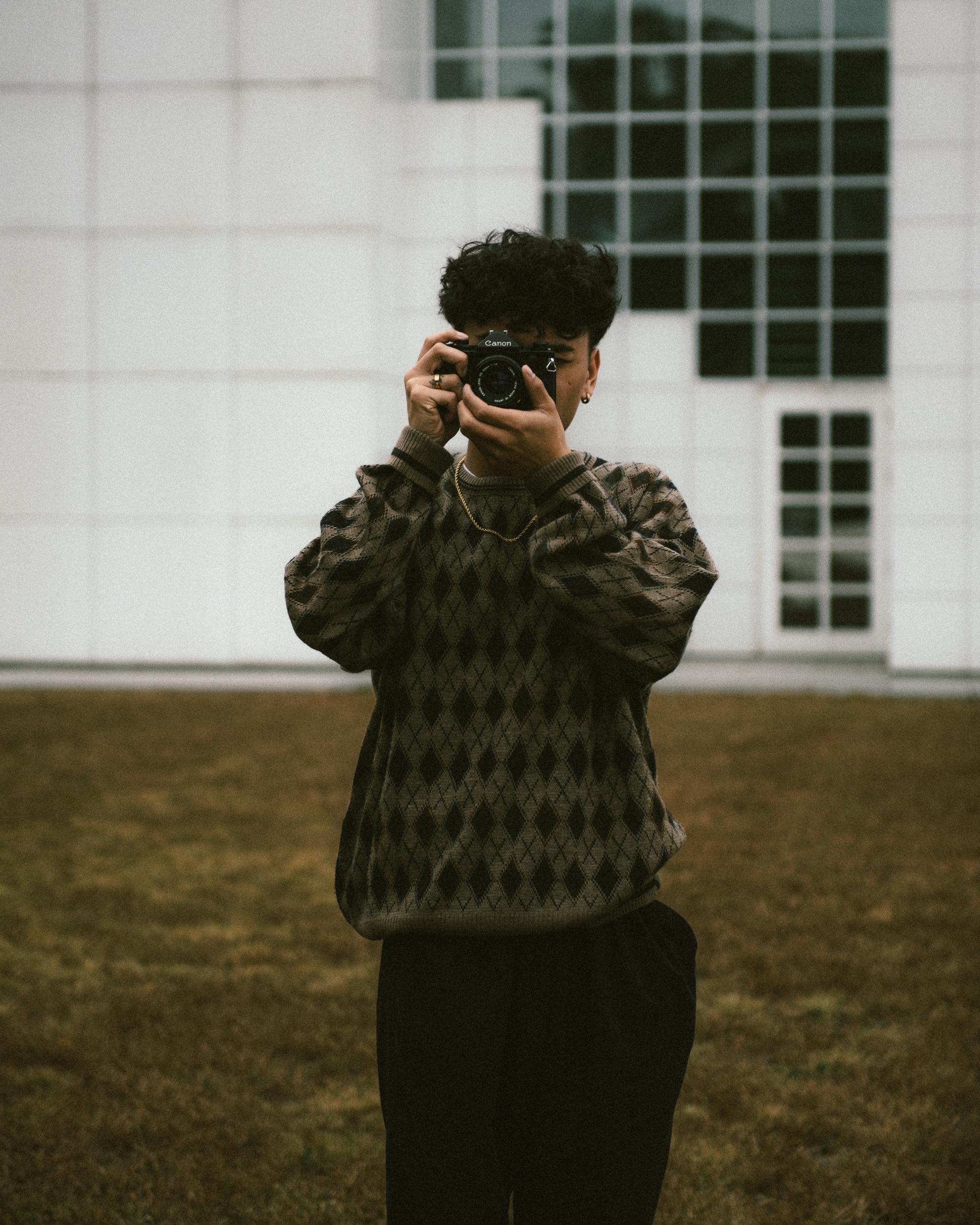 Young Man with Camera Standing in Front of Building · Free Stock Photo