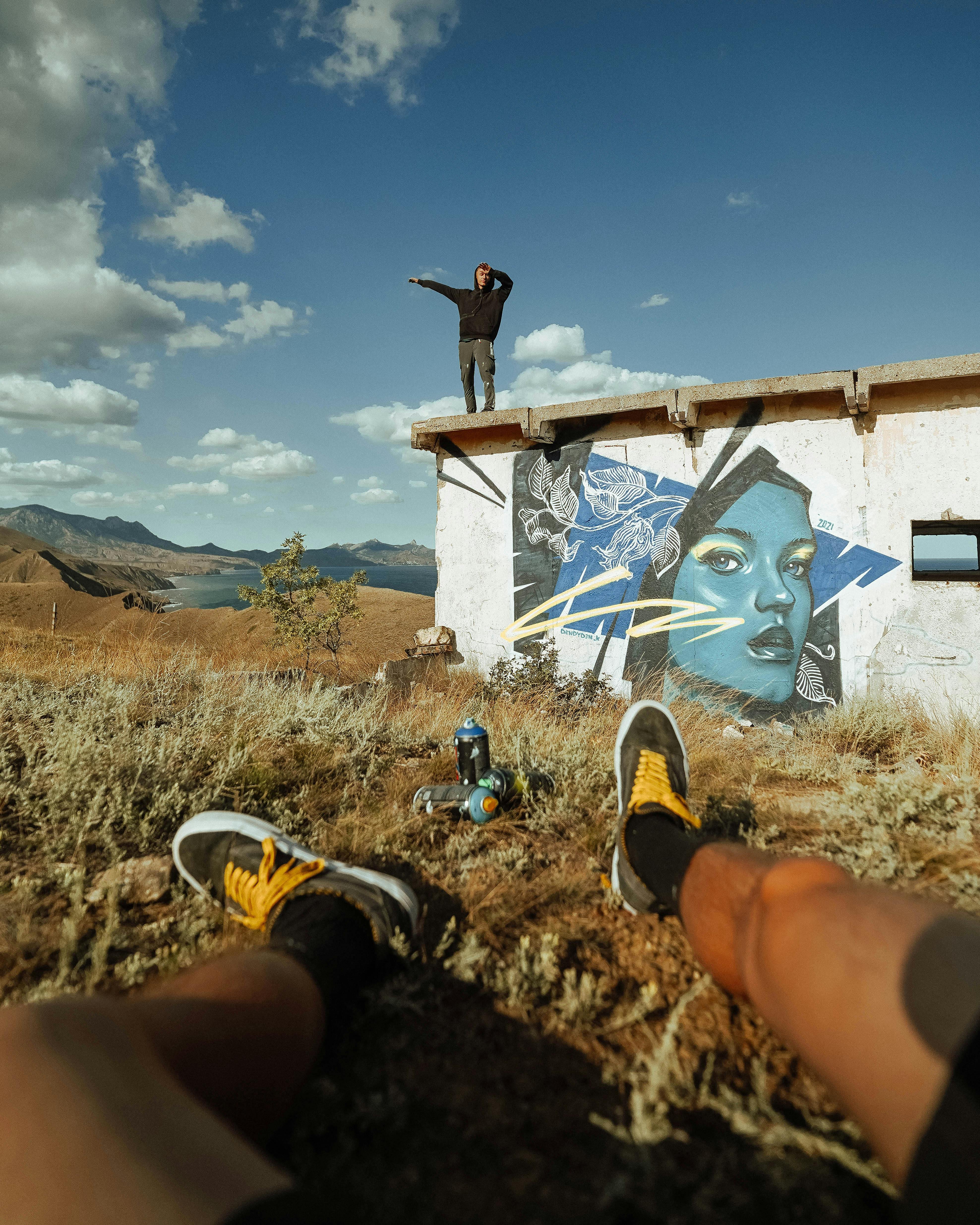 Man Standing on Roof of Building with Graffiti · Free Stock Photo