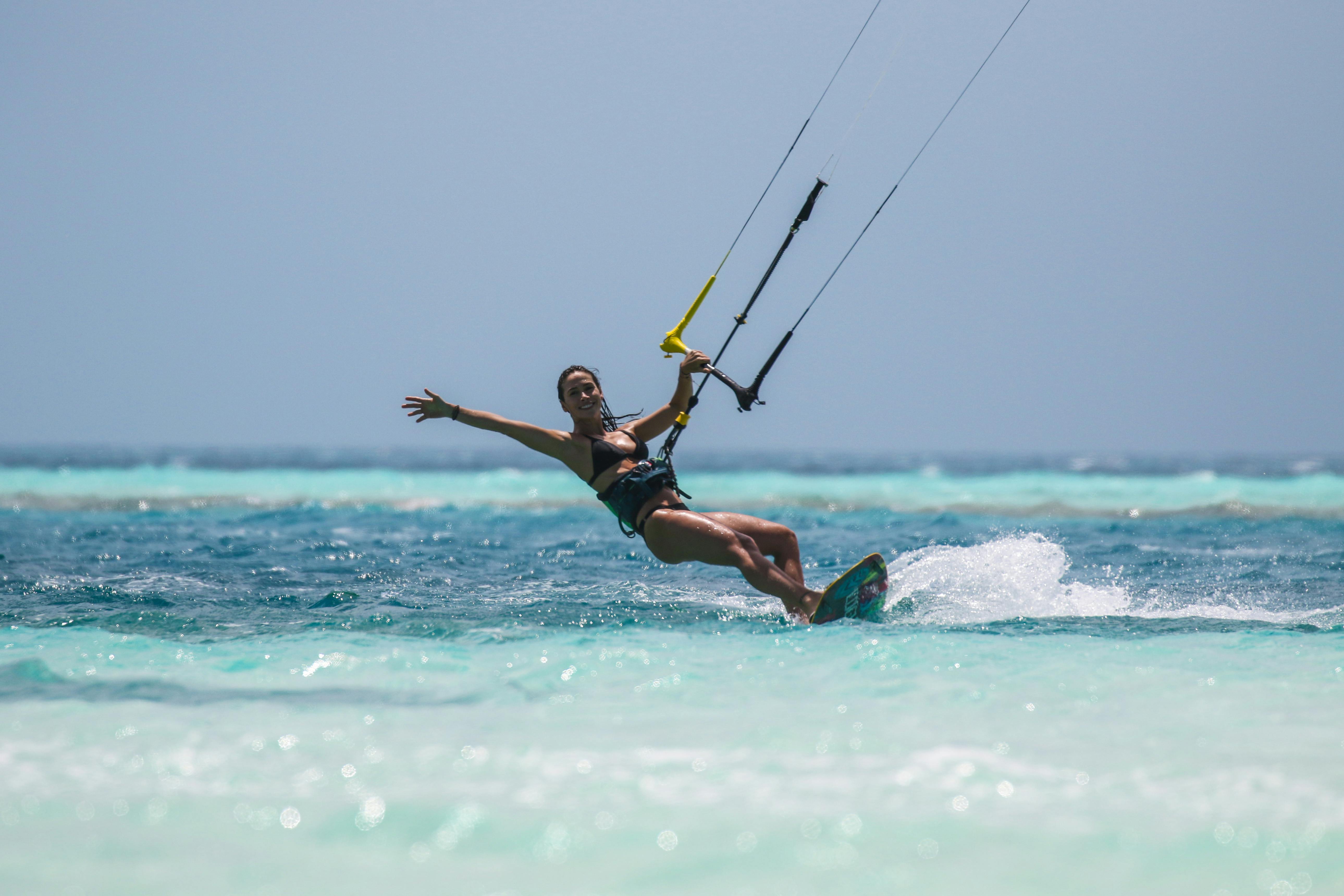A Woman in Black Bikini Kiteboarding on a Body of Water · Free Stock Photo
