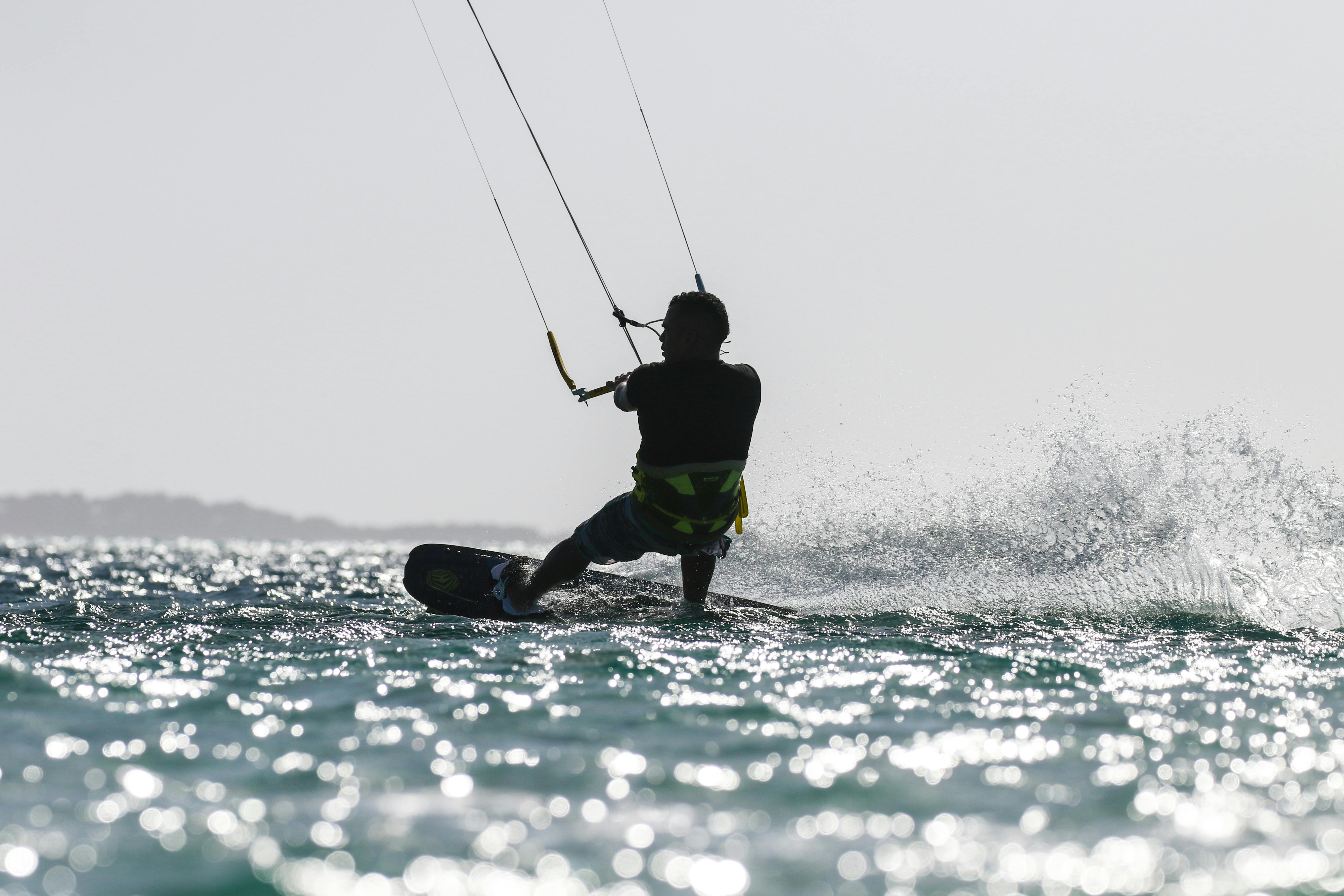 A Woman in Black Bikini Kiteboarding on a Body of Water · Free Stock Photo