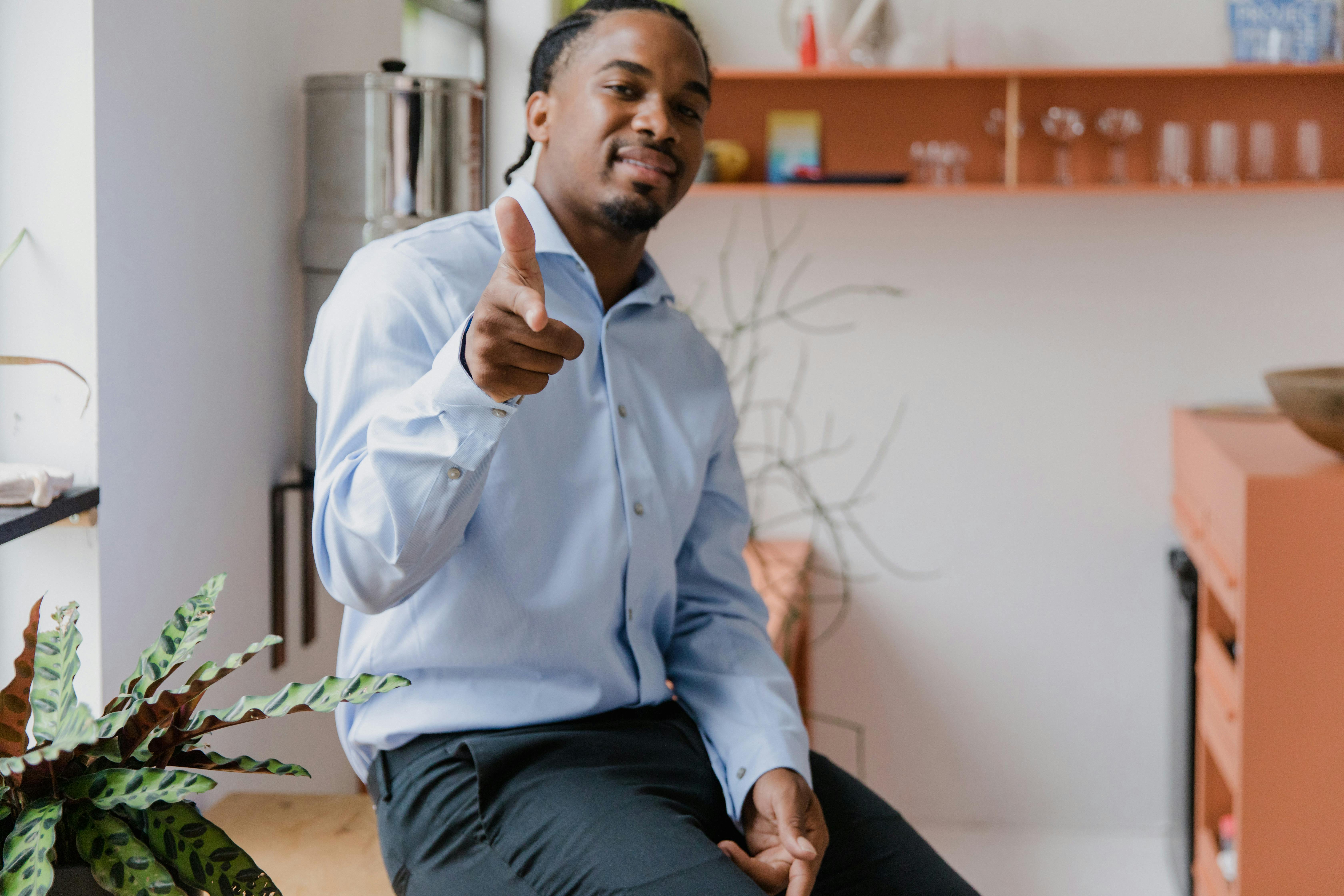 Portrait of Businessman Showing Sign Language in Office · Free Stock Photo