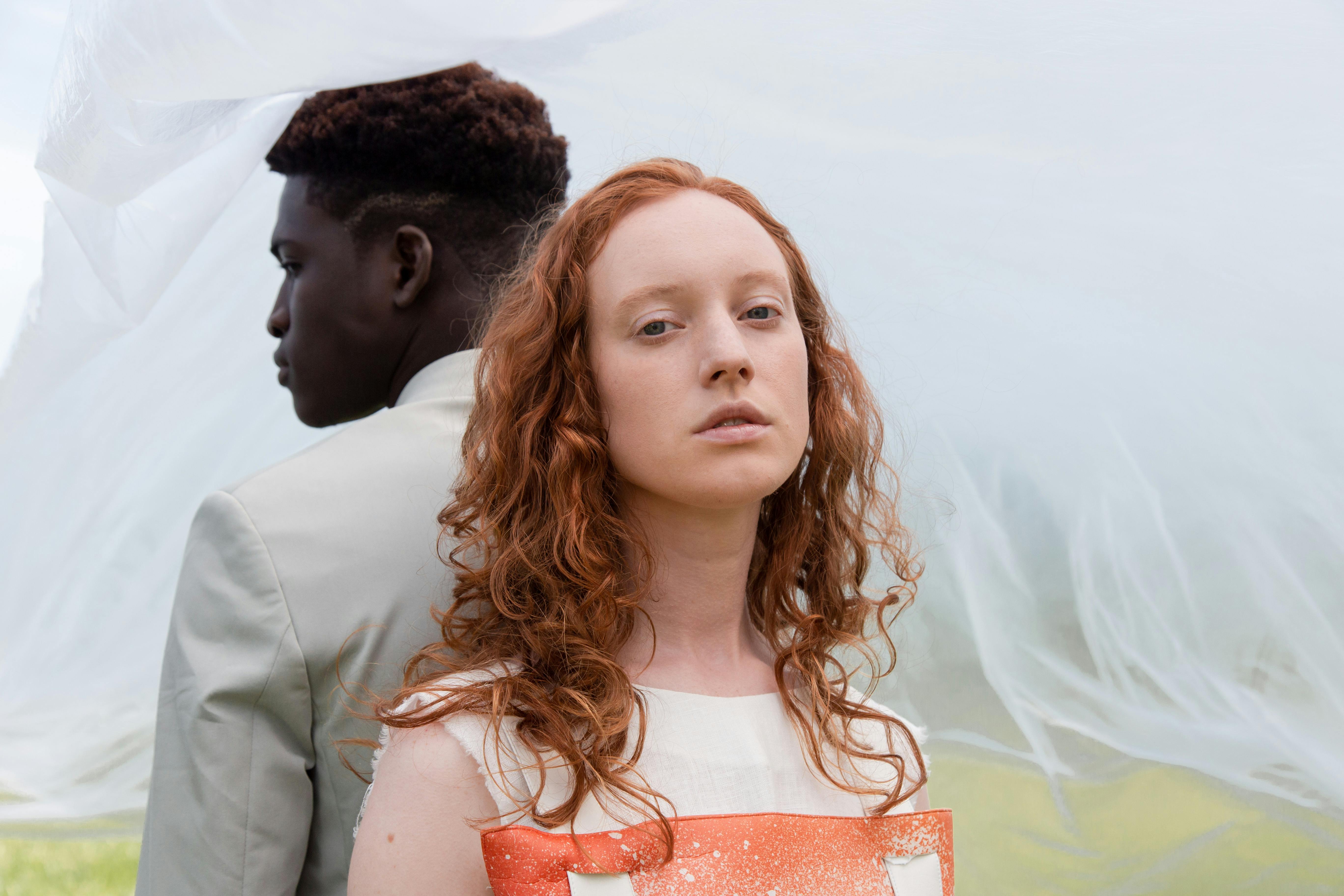 A Woman and a Man Standing Back to Back · Free Stock Photo