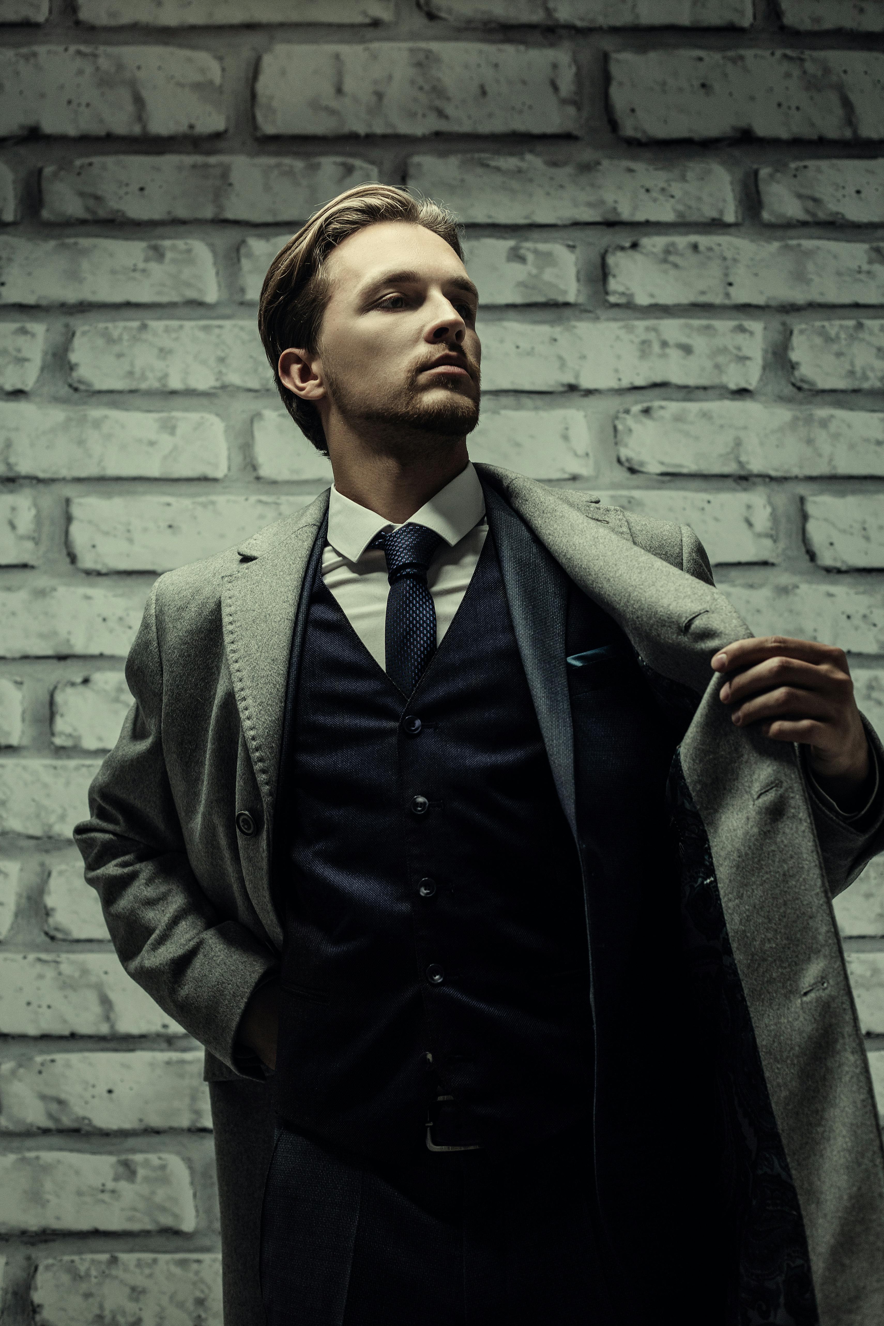 Elegant Man Putting on Coat · Free Stock Photo