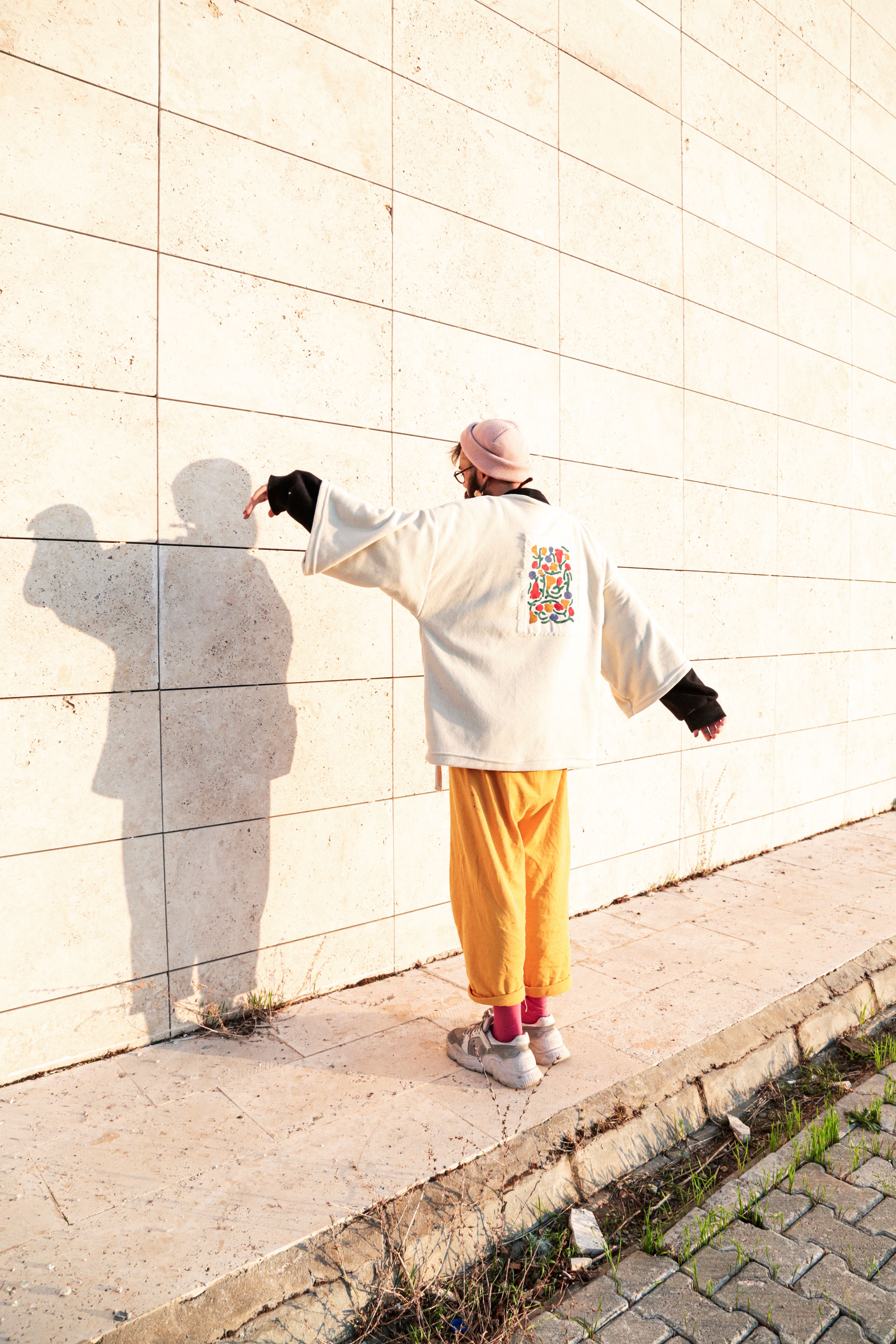 A Stylish Man Posing and Looking at His Shadow · Free Stock Photo
