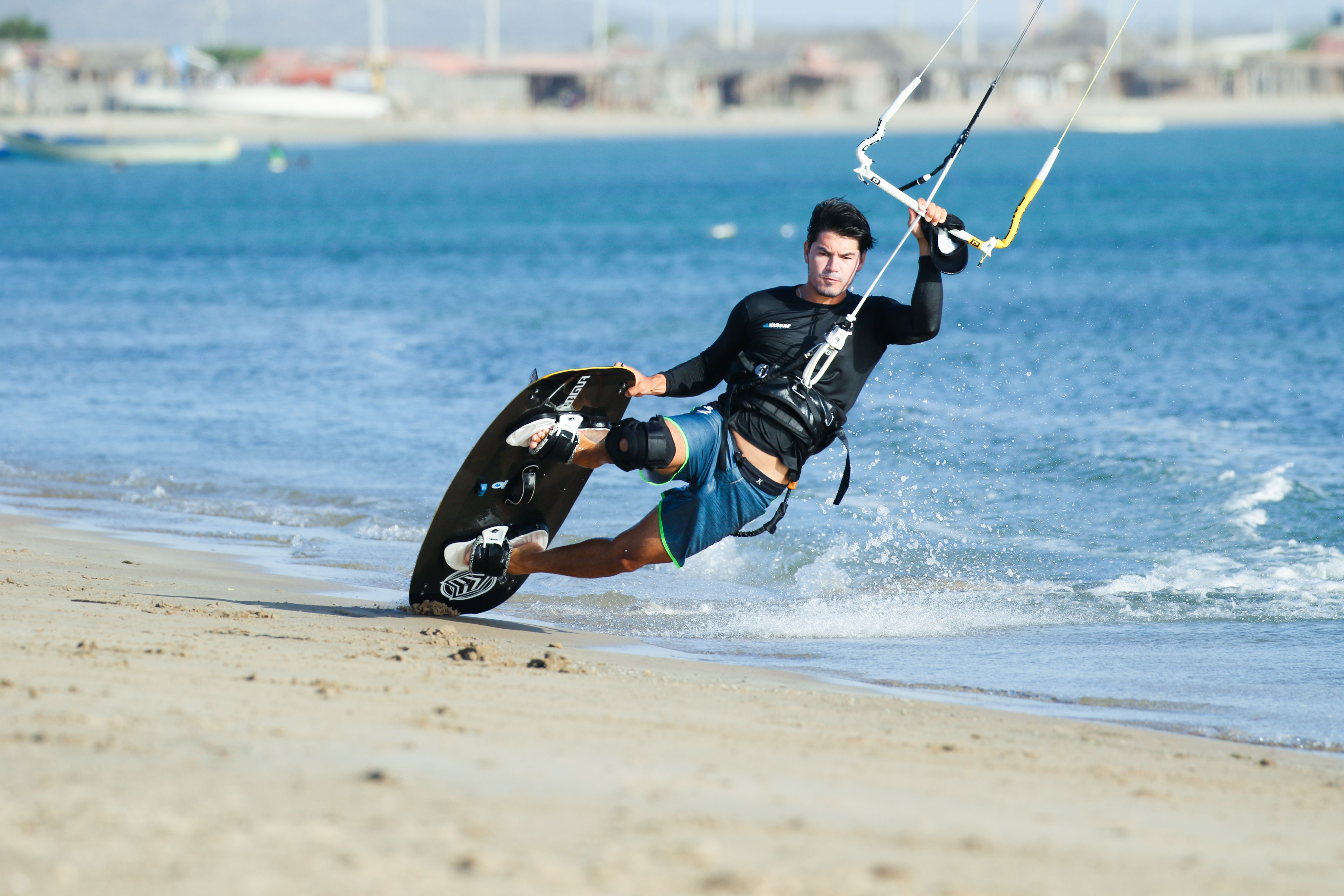 Man Wearing a Wetsuit Kite Boarding on Sea · Free Stock Photo