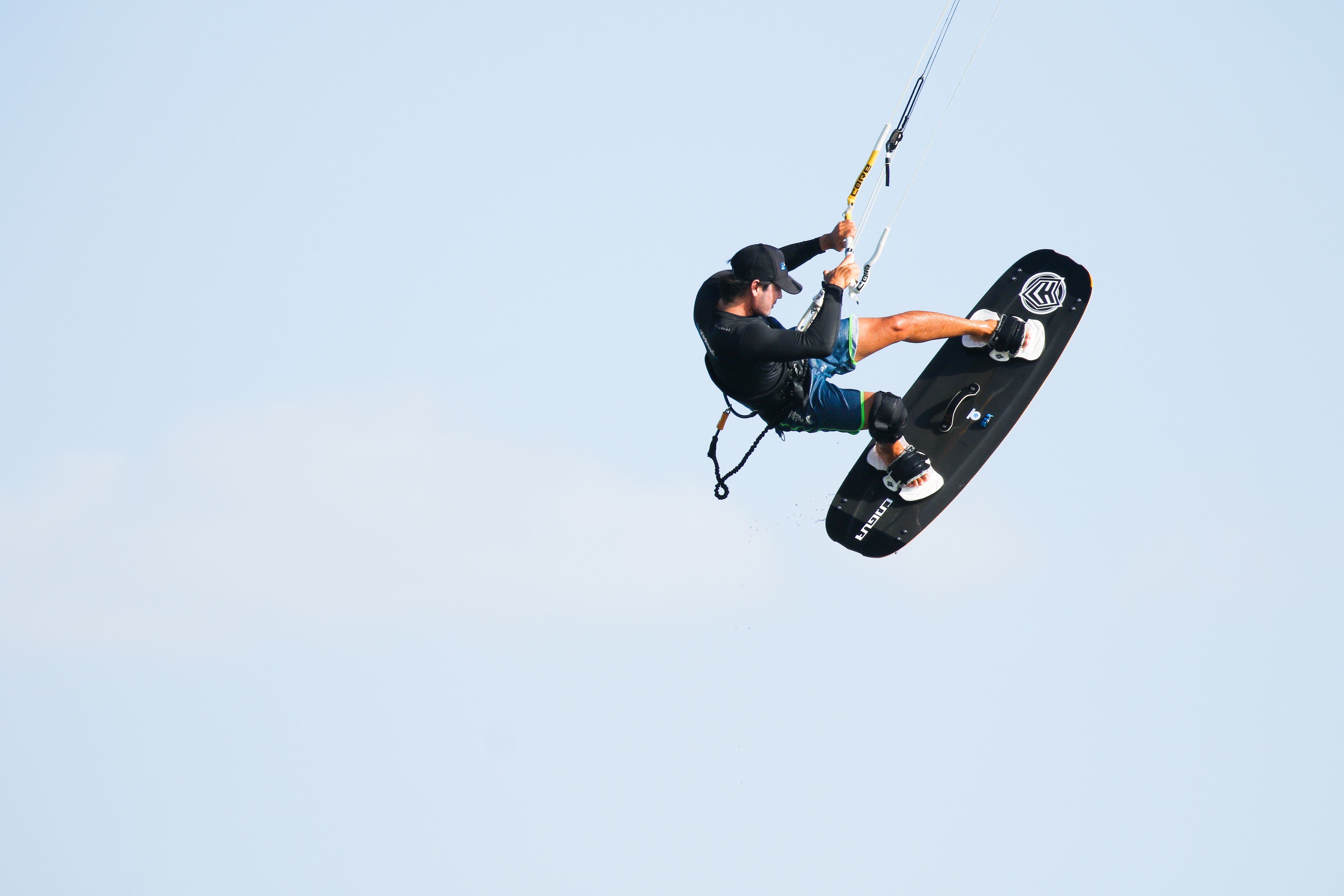 Anonymous kiteboarders balancing on stormy sea while practicing ...