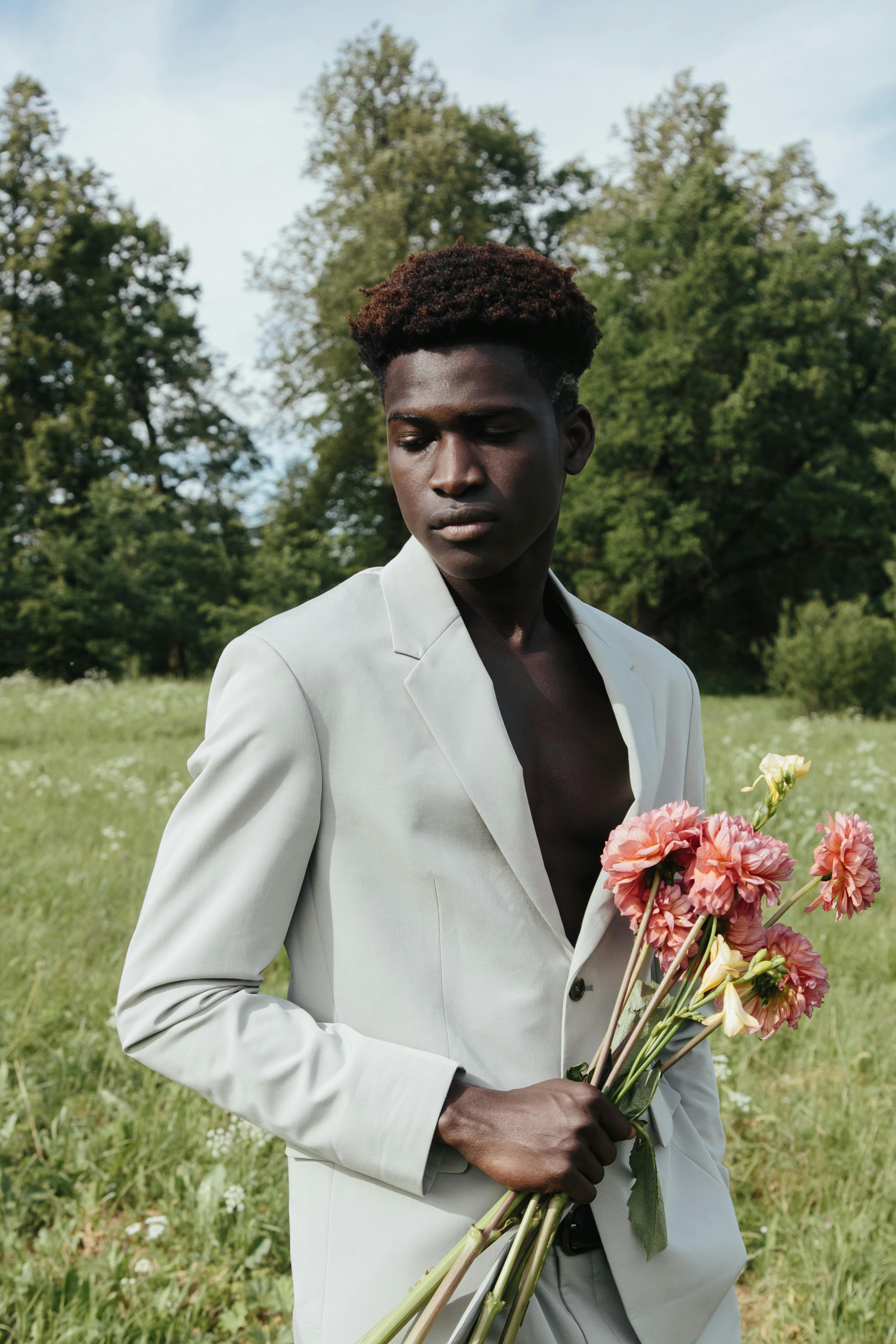 Man Wearing a White Blazer Holding Bunch of Flowers · Free Stock Photo