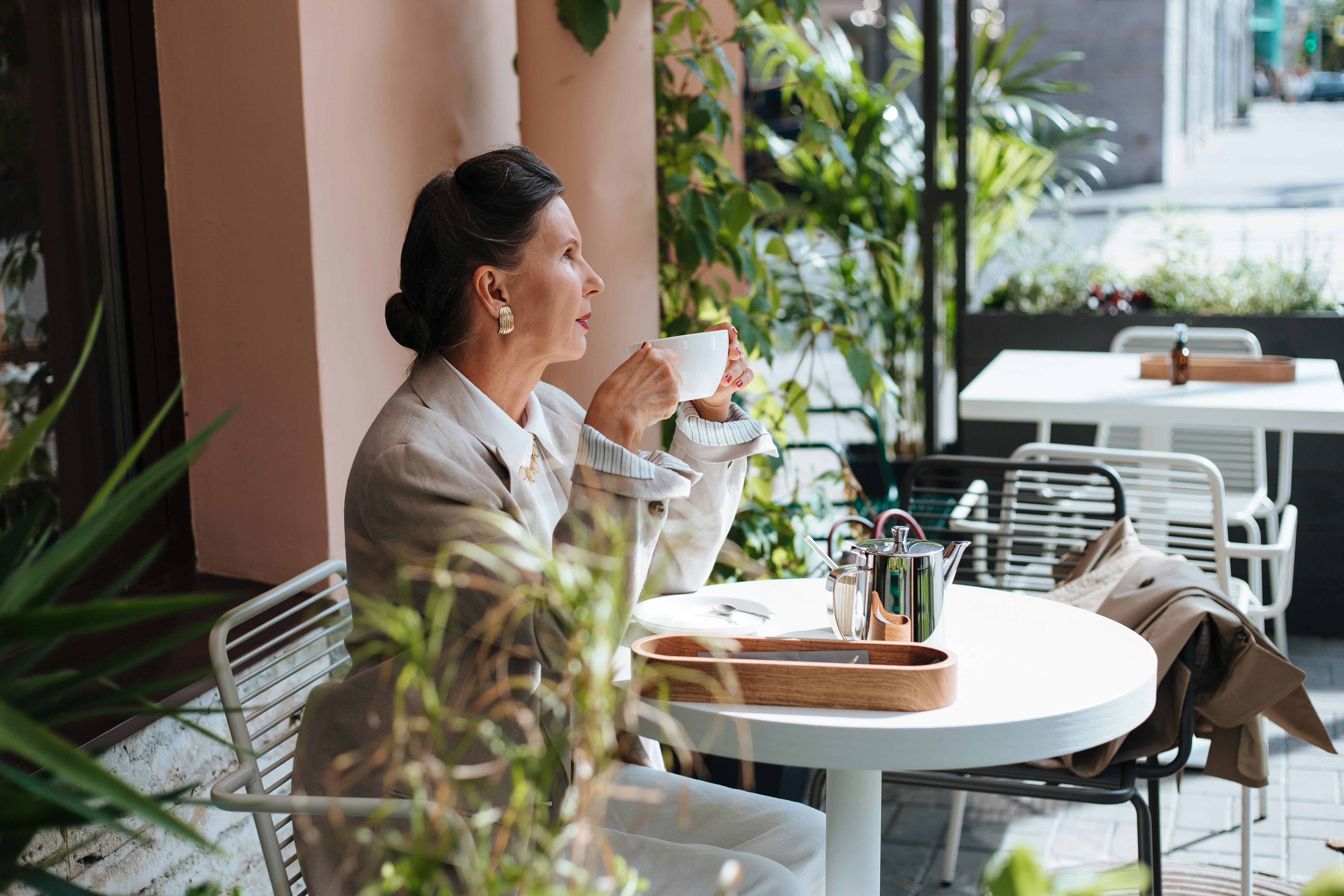 A Woman Drinking Coffee on an Outdoor Coffee Shop · Free Stock Photo