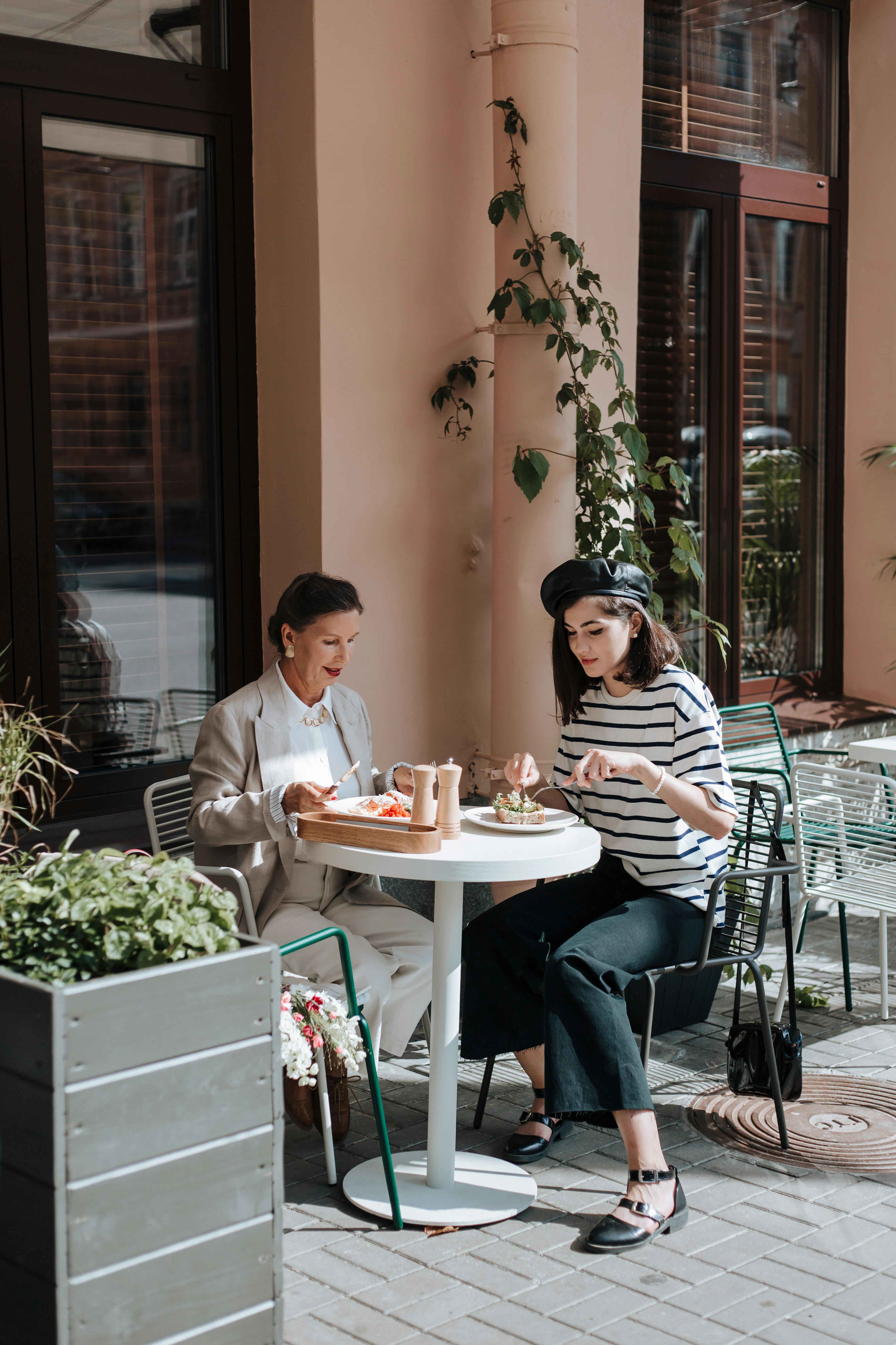 Women Sitting Outside the Café while Having Conversation · Free Stock Photo