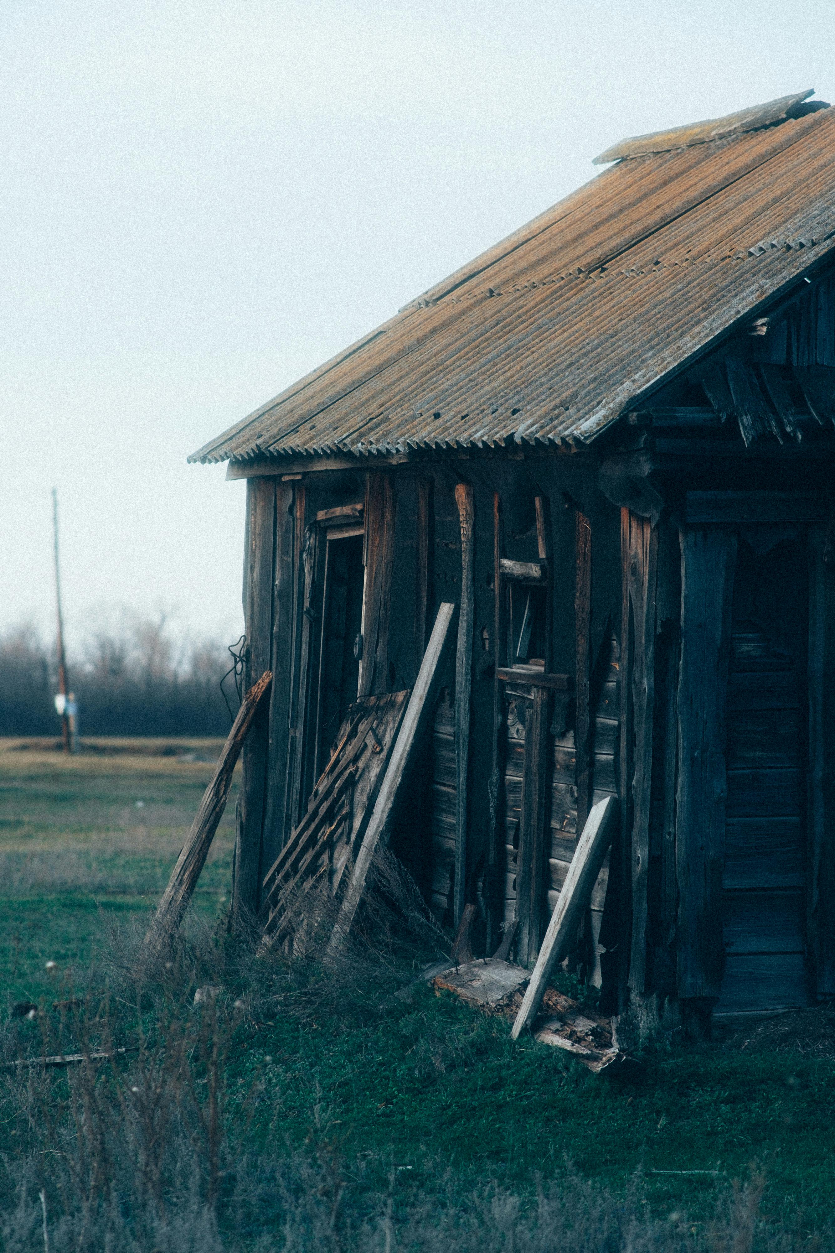 An Old Shabby Wooden House on Open Field · Free Stock Photo