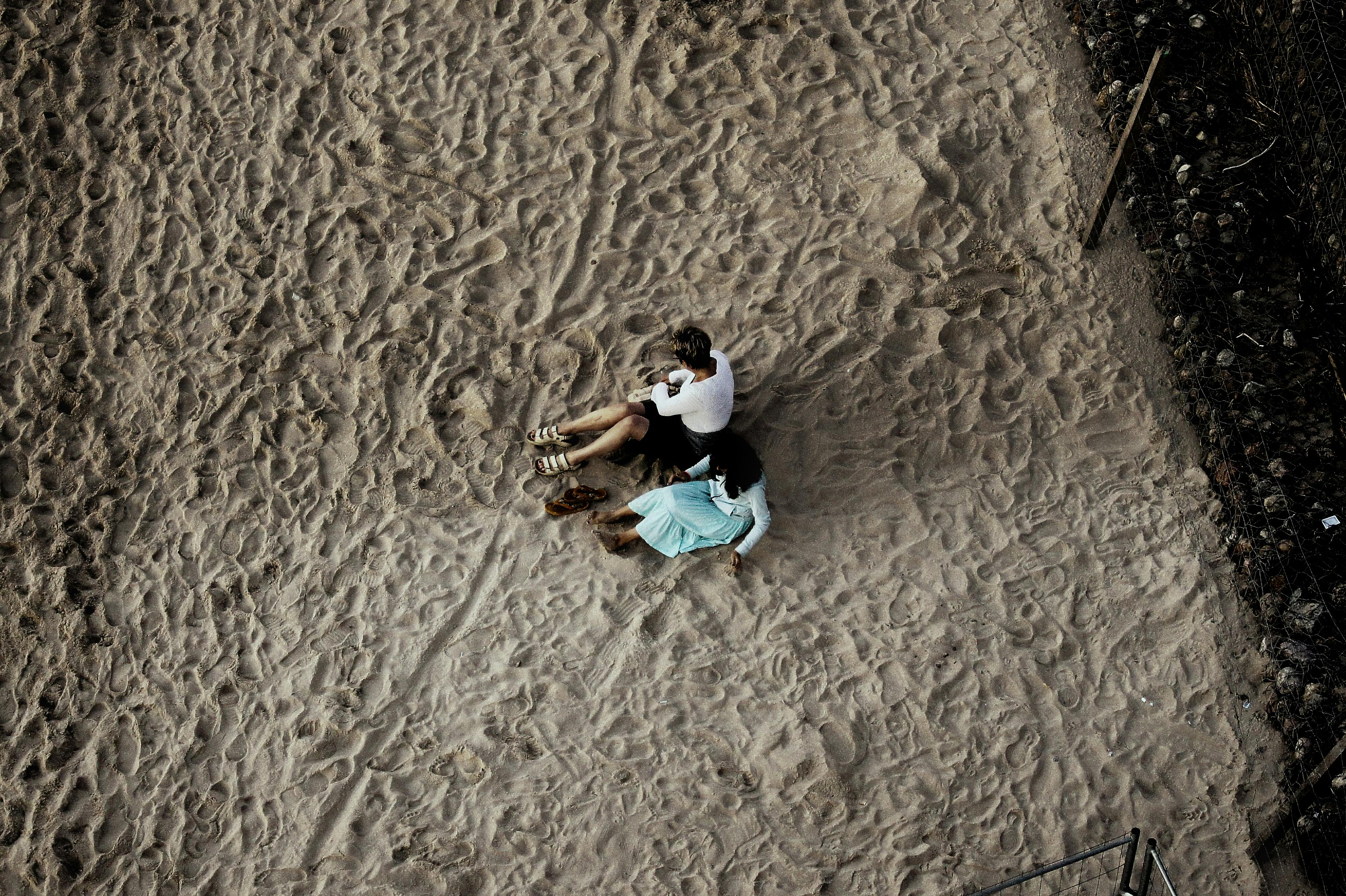 Drone Shot of Women Sitting on the Sand · Free Stock Photo