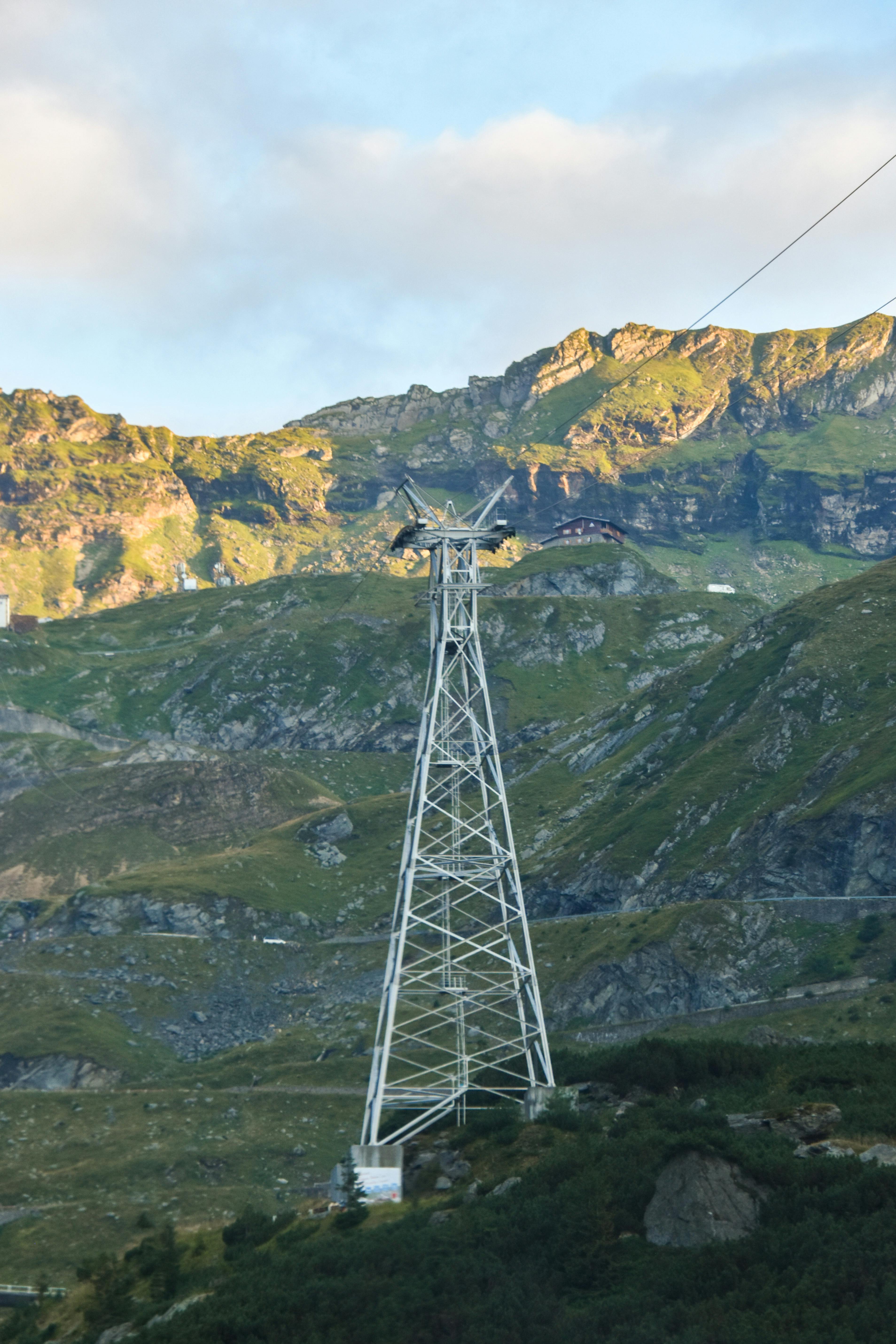 White Transmission Tower Near Green Mountains · Free Stock Photo