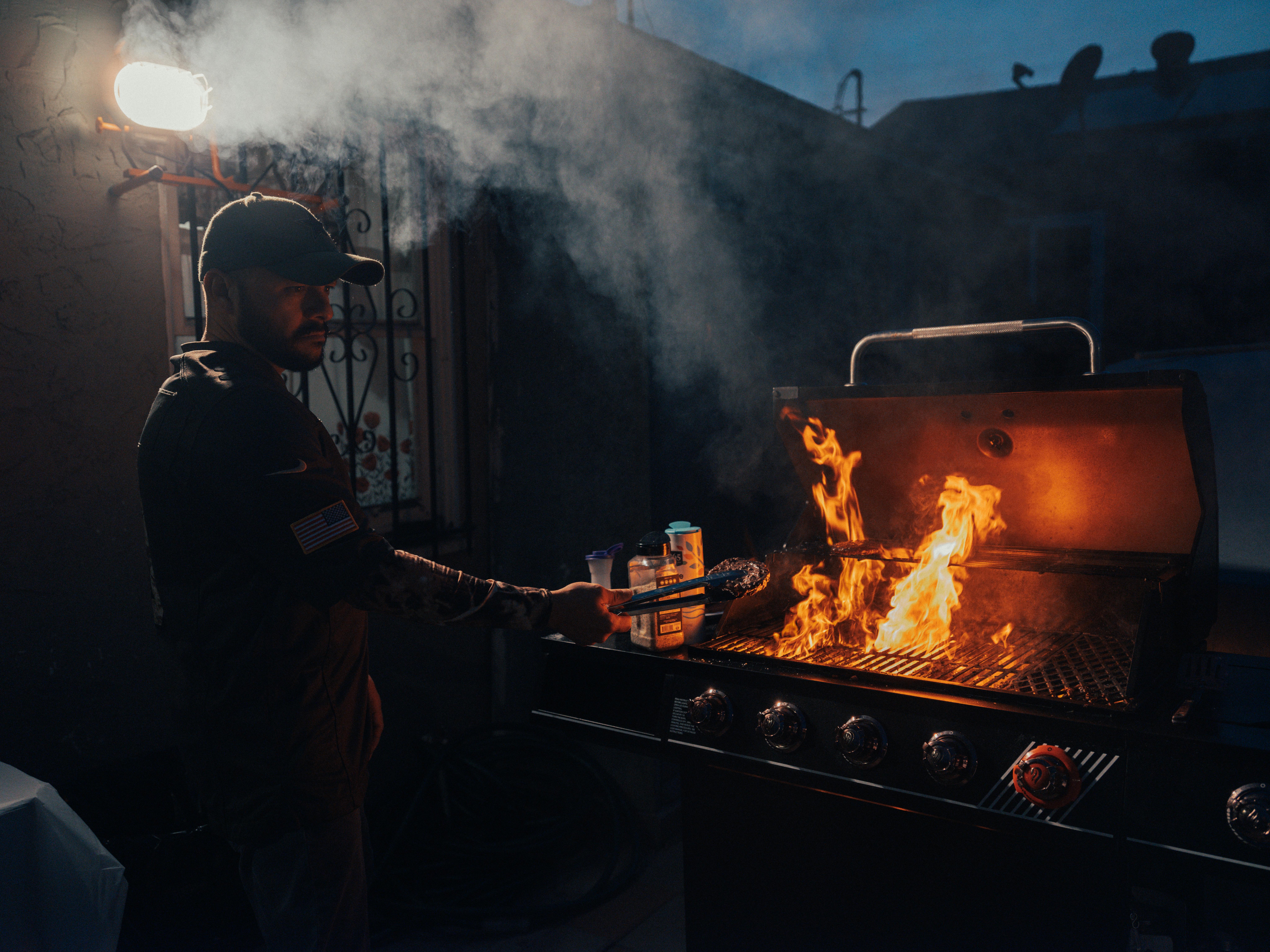 Man Grilling a Barbeque on the Backyard · Free Stock Photo