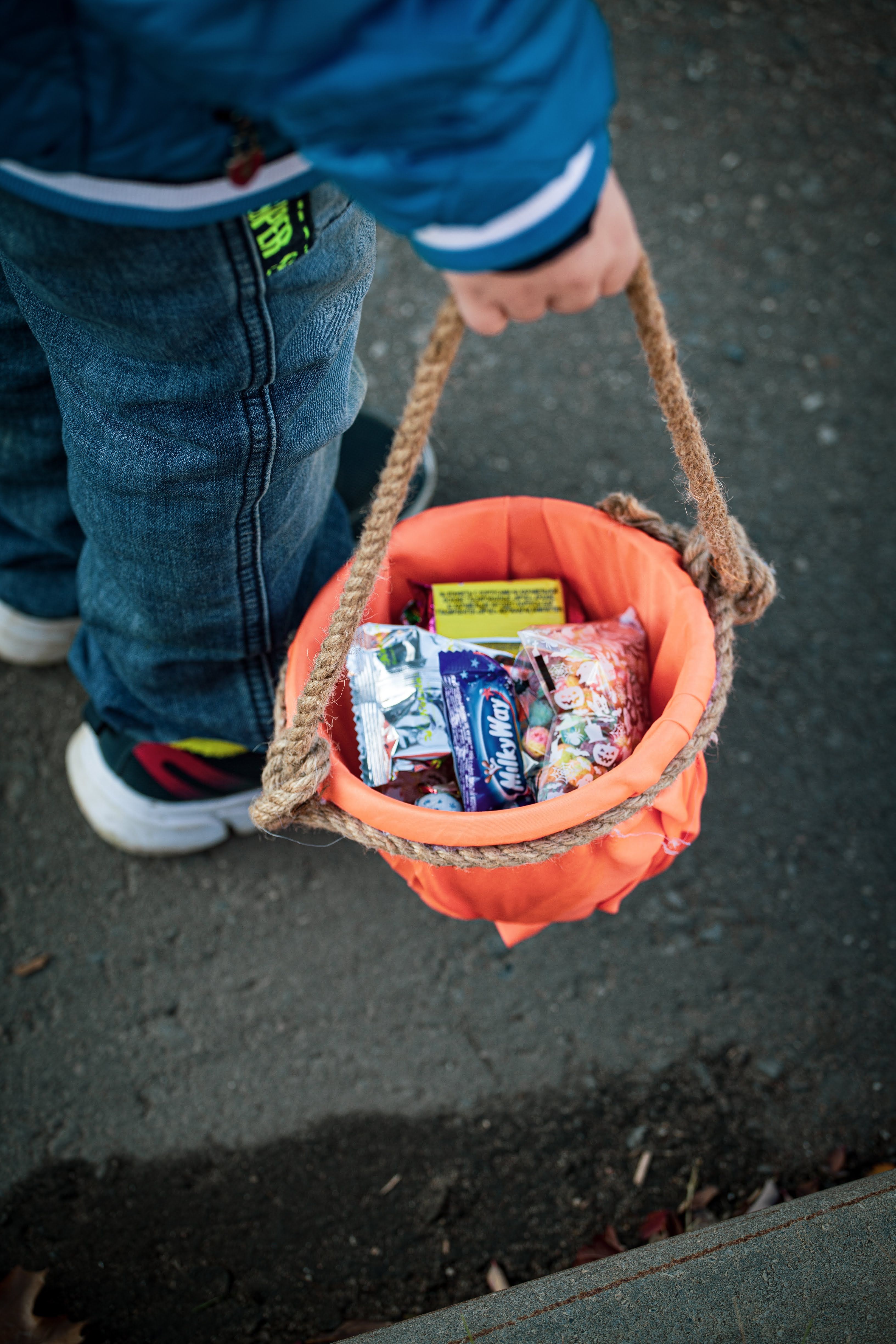 Photograph of a Kid's Hand Holding a Basket with Candies · Free Stock Photo