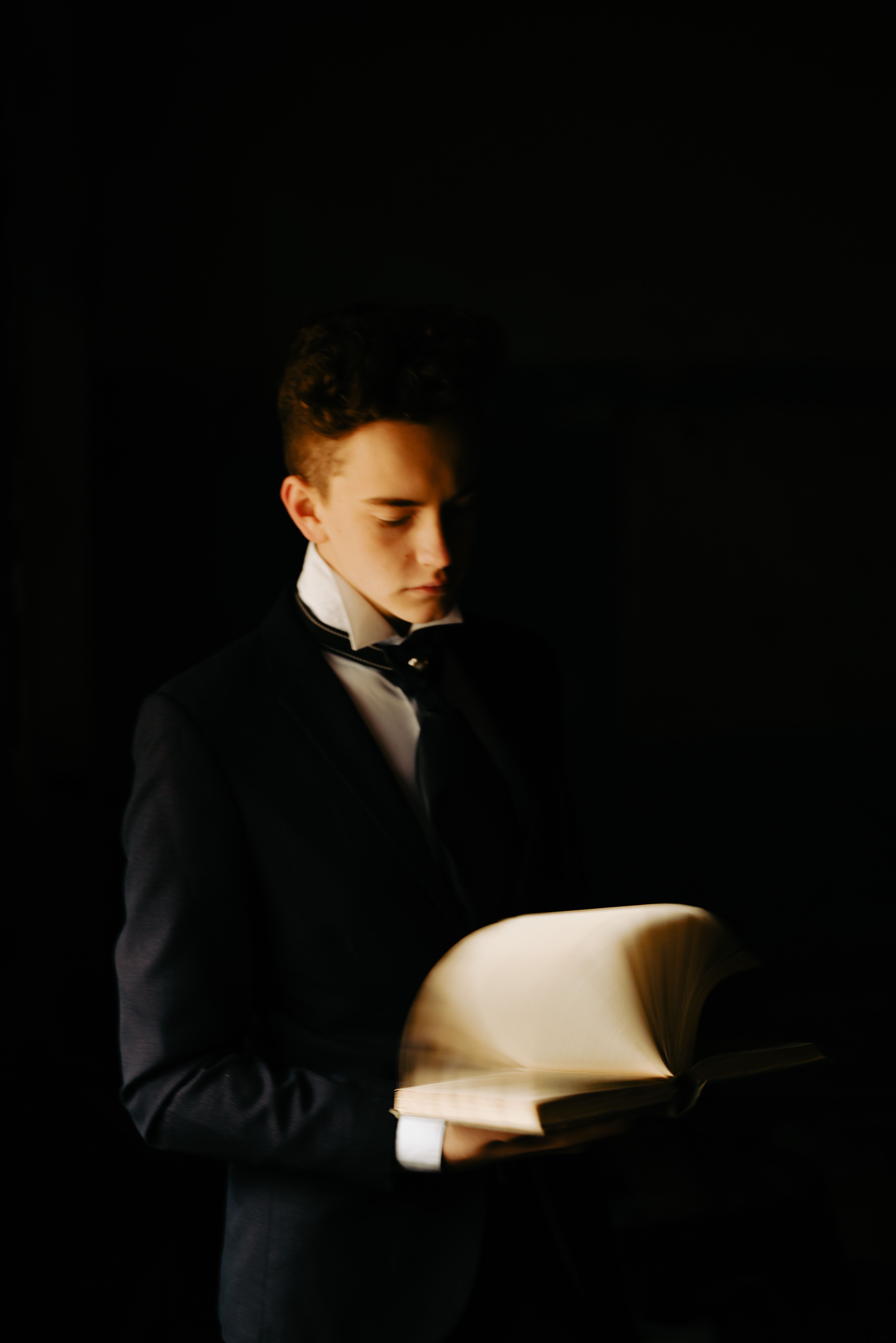 Young Man on Black Background Reading Book · Free Stock Photo
