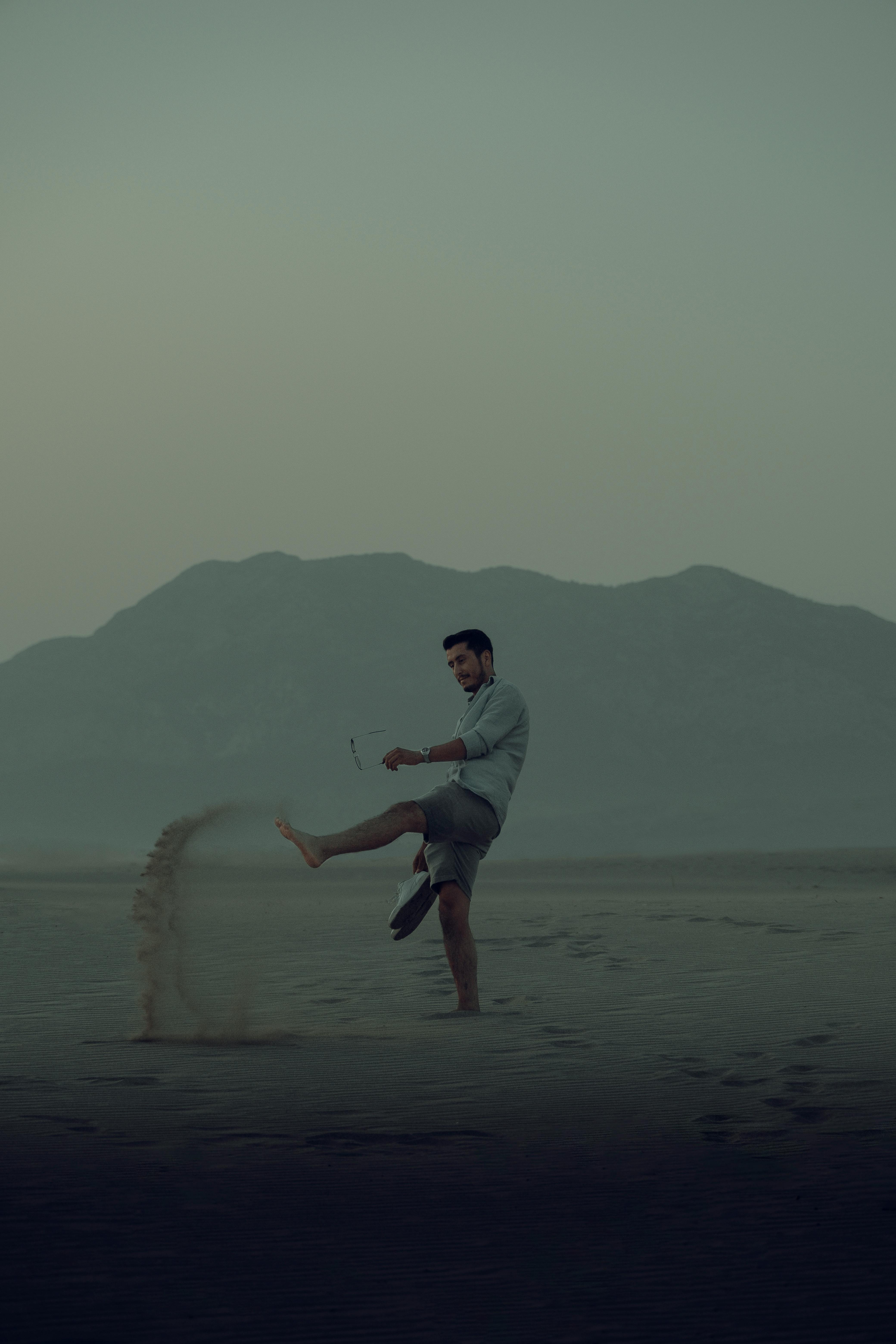 A Man Kicking Sand on Shore · Free Stock Photo