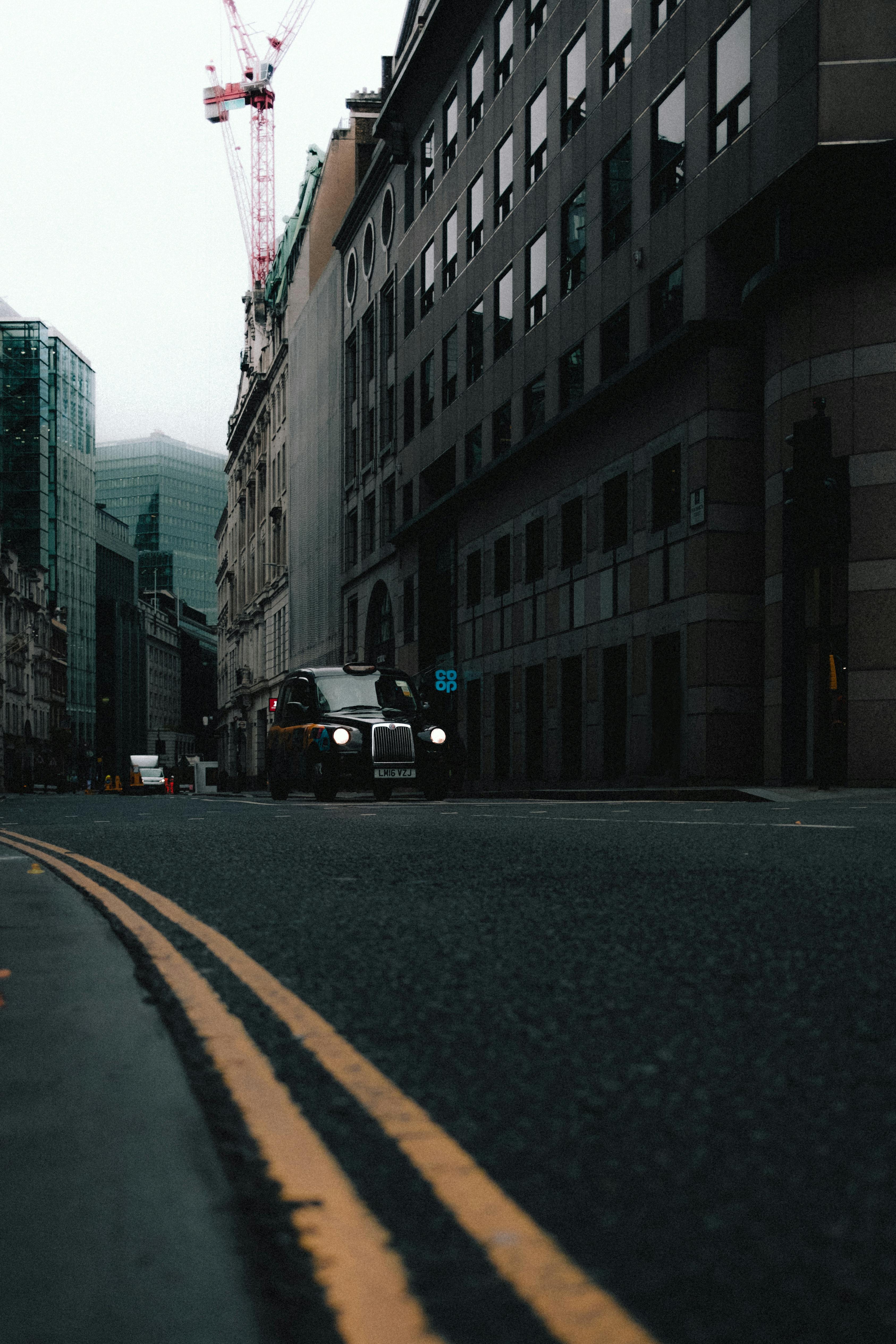 Photo of a Black Car Between Buildings · Free Stock Photo