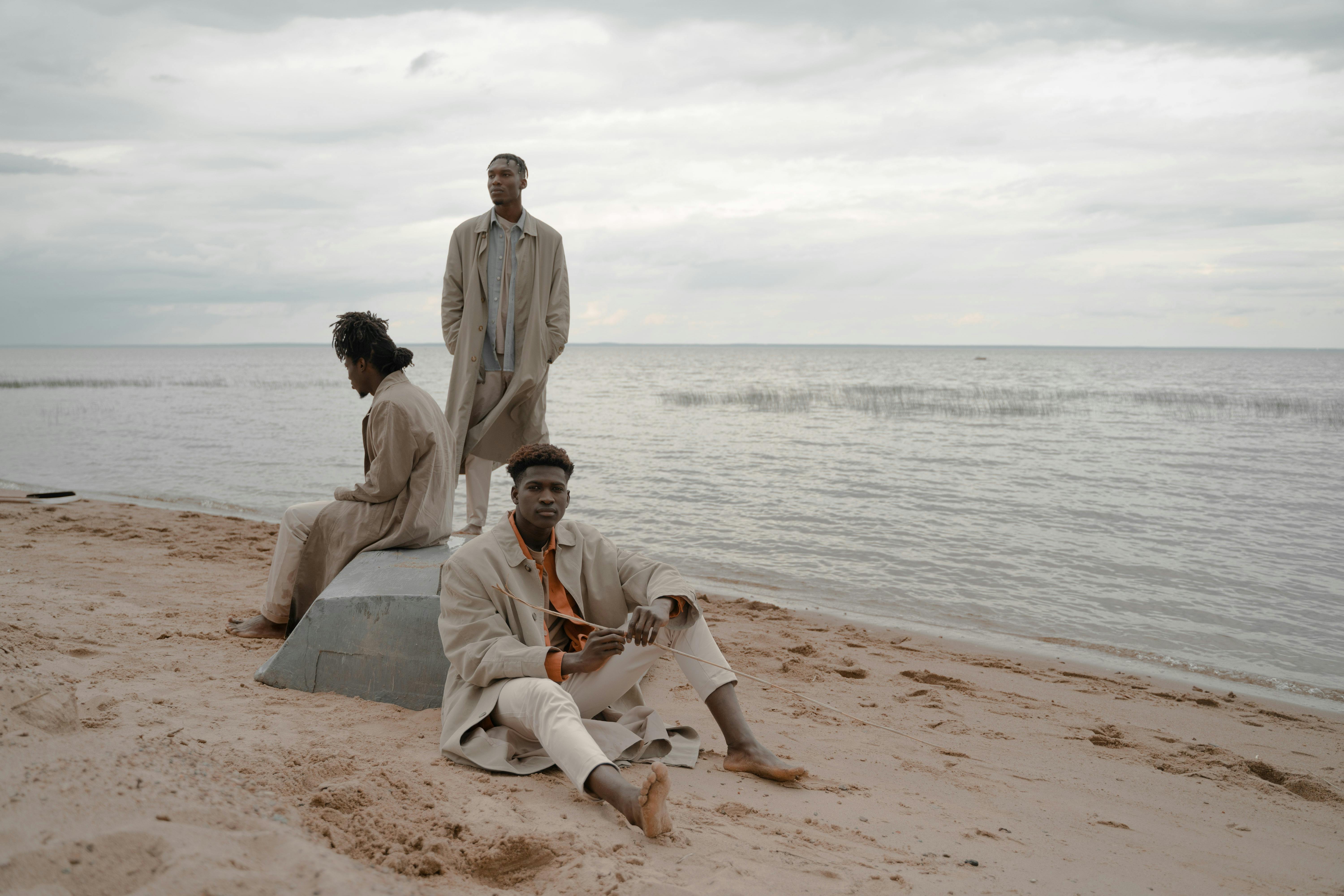 Men Sitting on Beach Beside Boat · Free Stock Photo