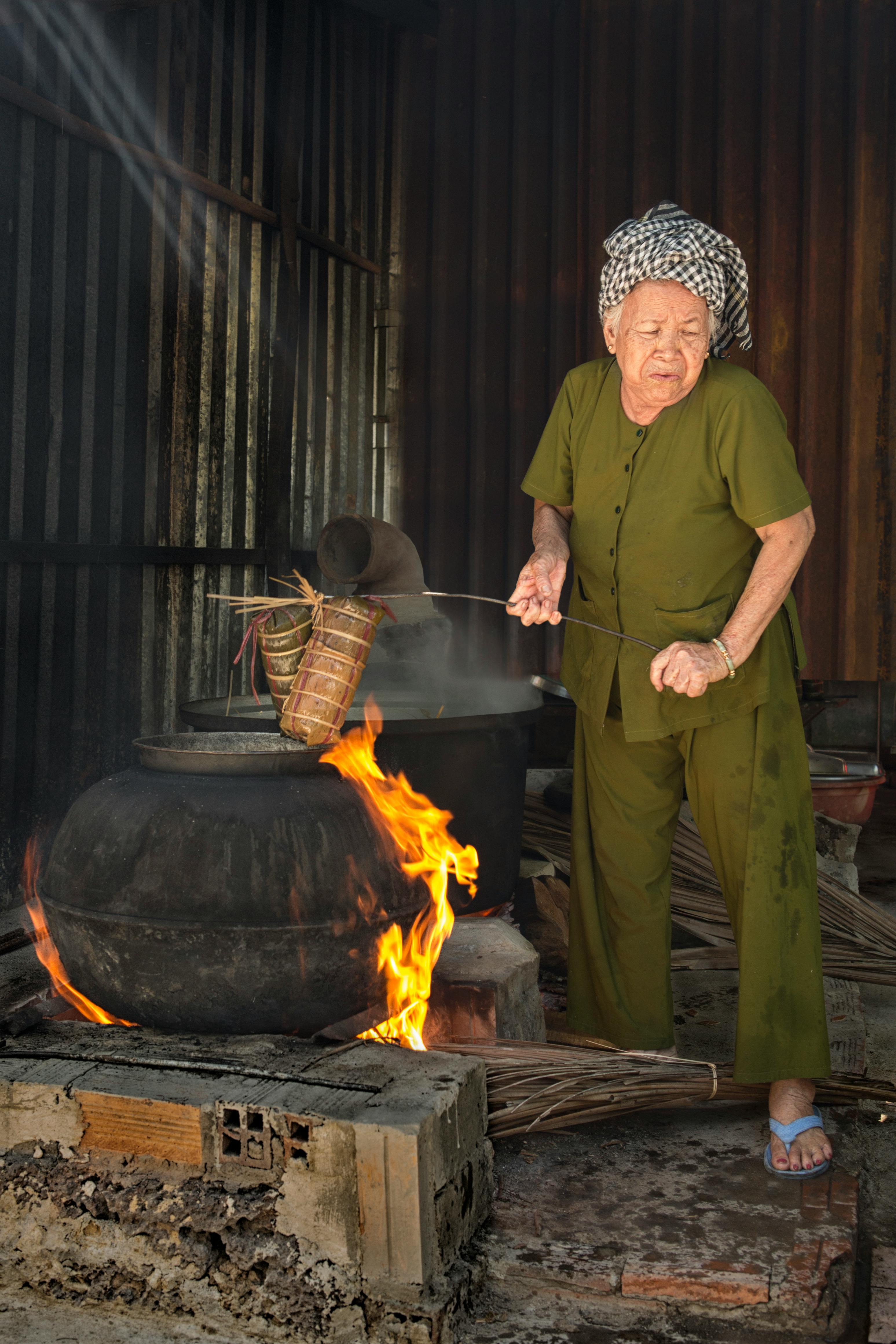 Lady Cooking Over Fire Pit