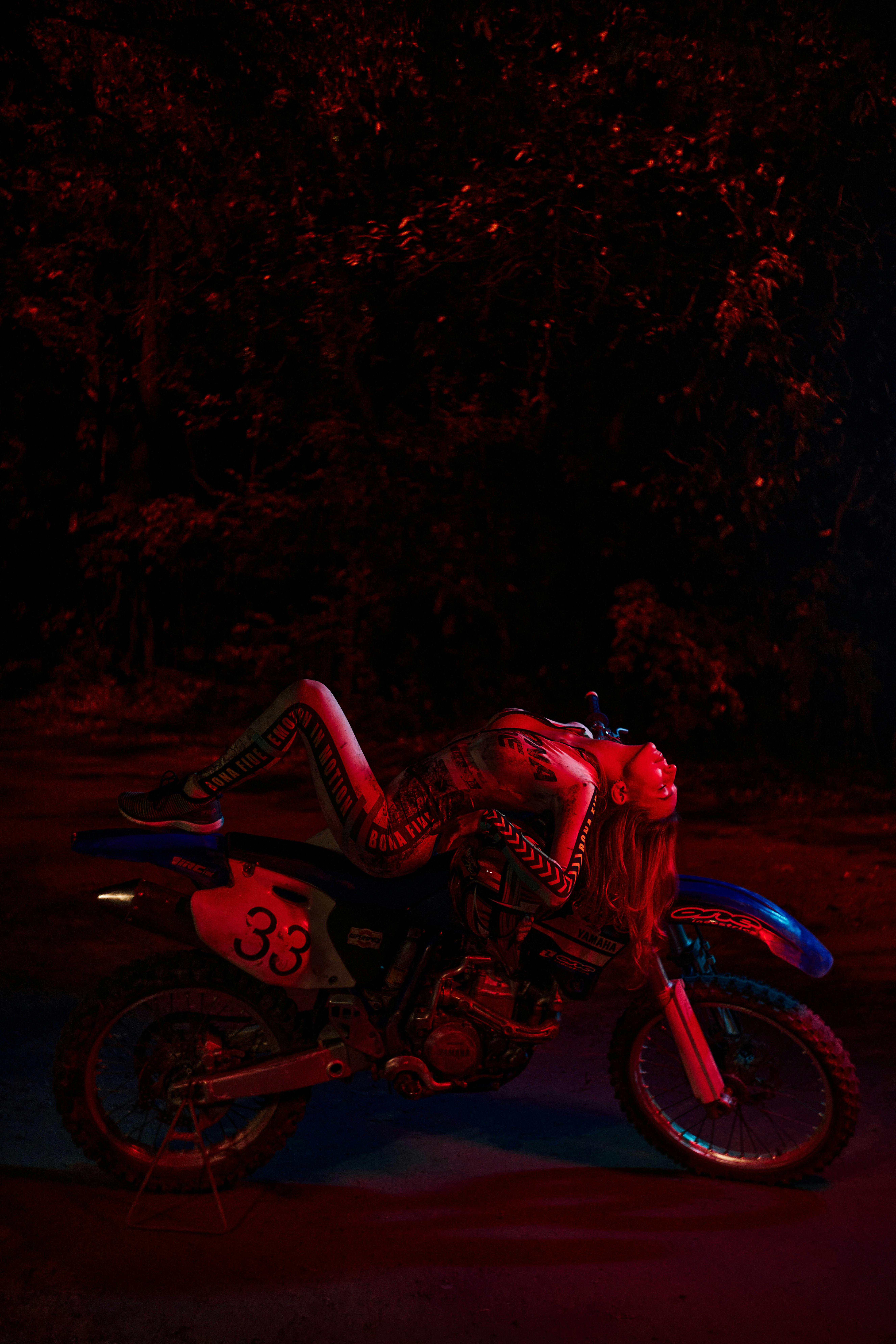 A Woman Lying Down on a Parked Motorcycle · Free Stock Photo