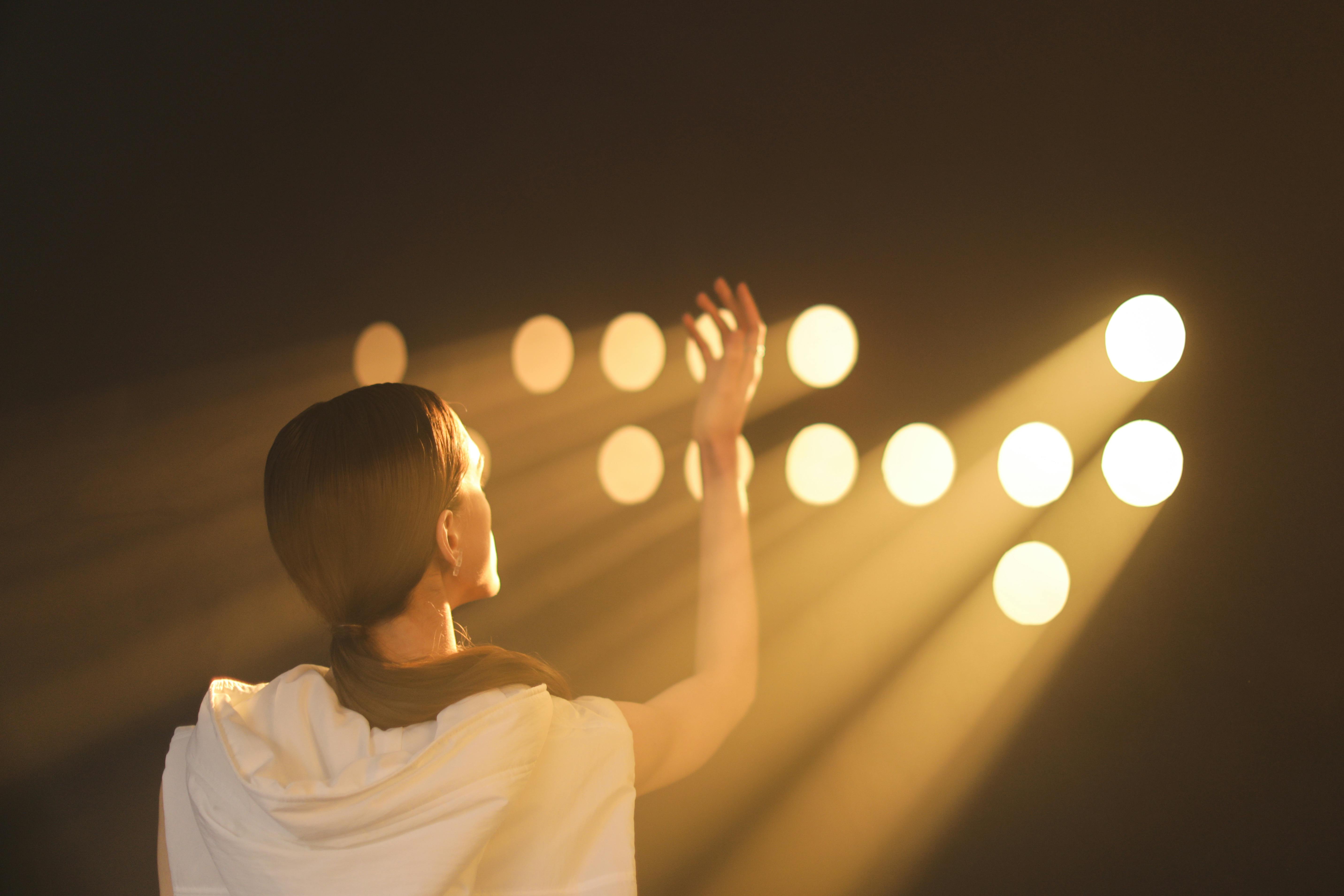 Circles of Lights over Woman Standing with Hand Raised · Free Stock Photo