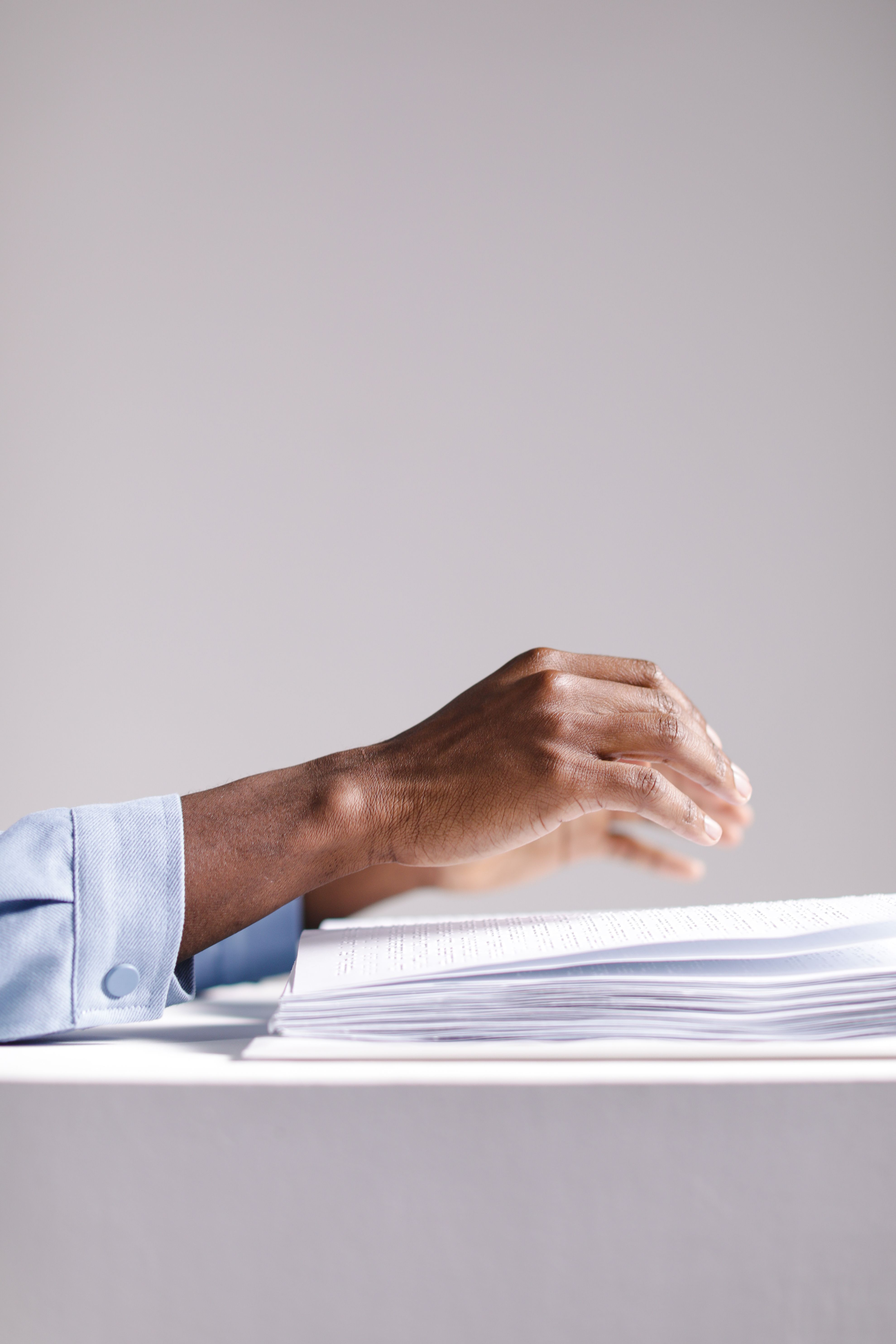 A Person Hand over a White Table · Free Stock Photo