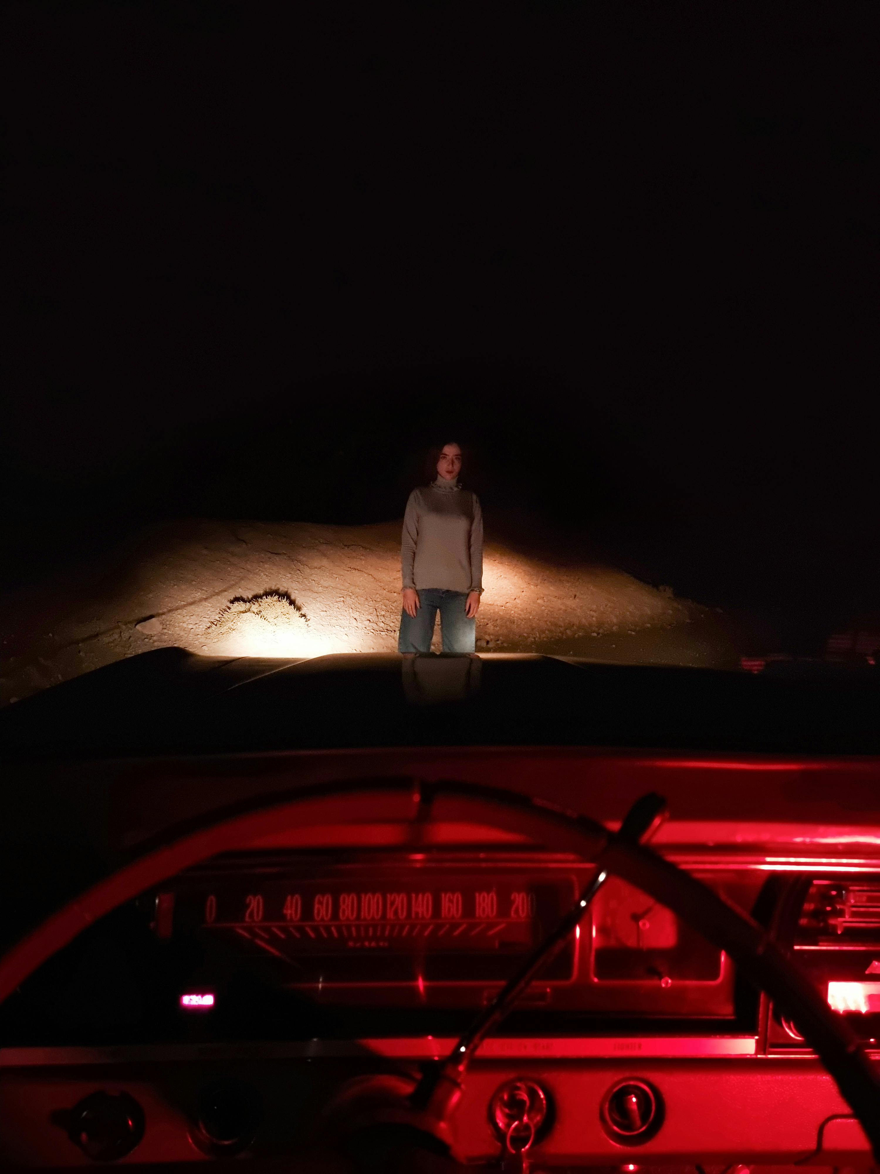 Woman Standing in Car Headlights · Free Stock Photo