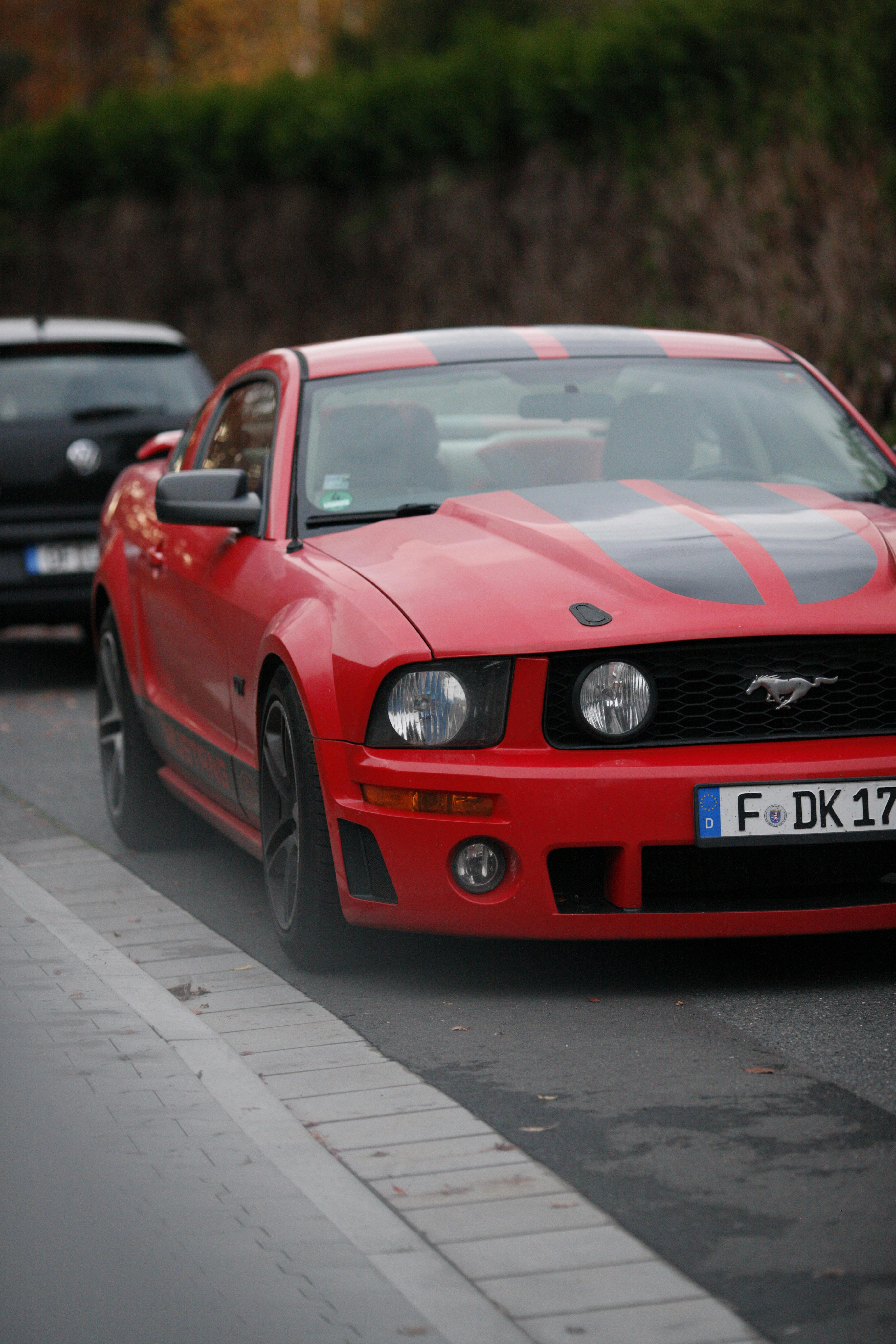 Close-Up Shot of a Red Sports Car on Concrete Road · Free Stock Photo