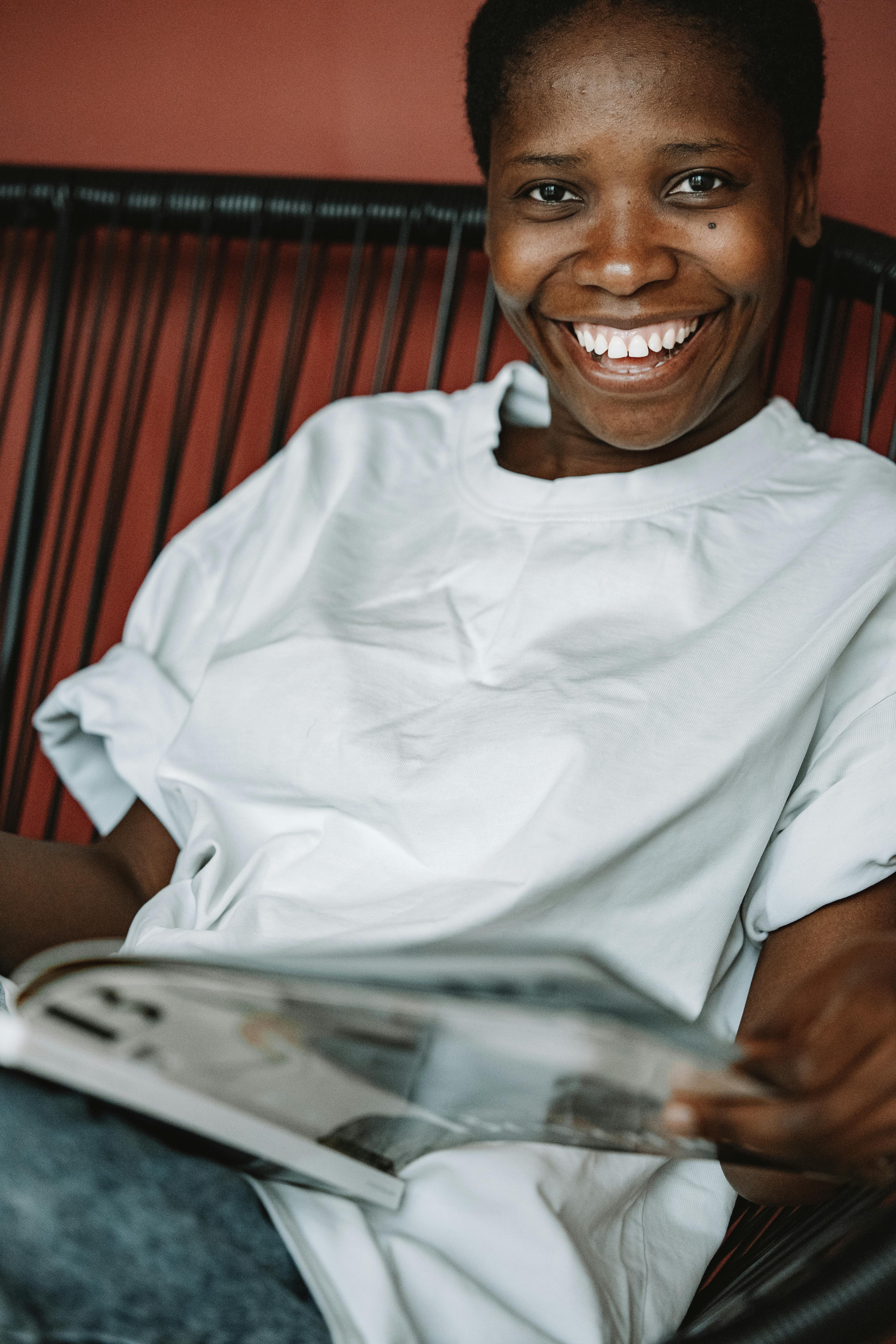 Portrait of Smiling Woman Holding Magazine · Free Stock Photo