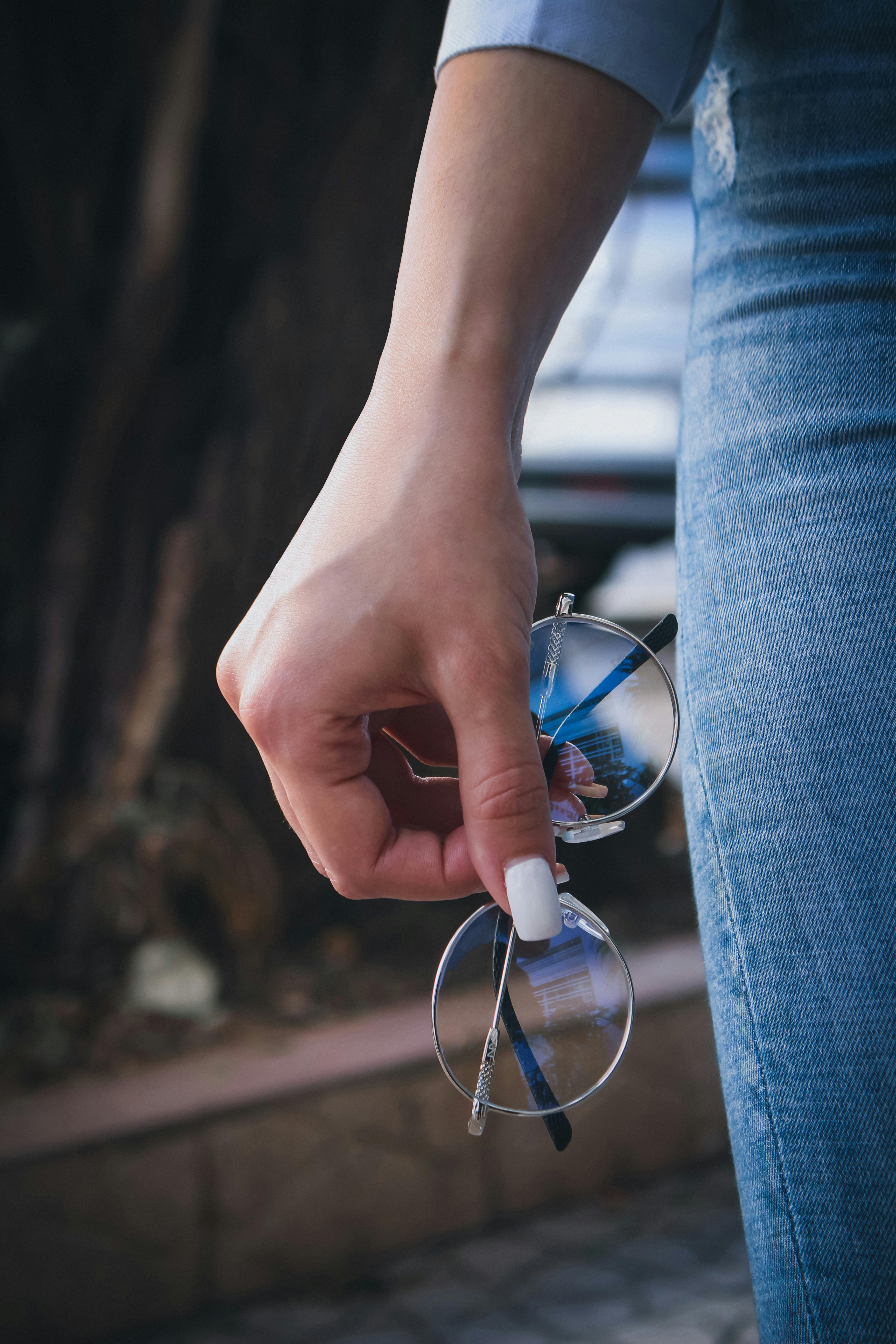 A Person Holding a Pair of Eyeglasses · Free Stock Photo