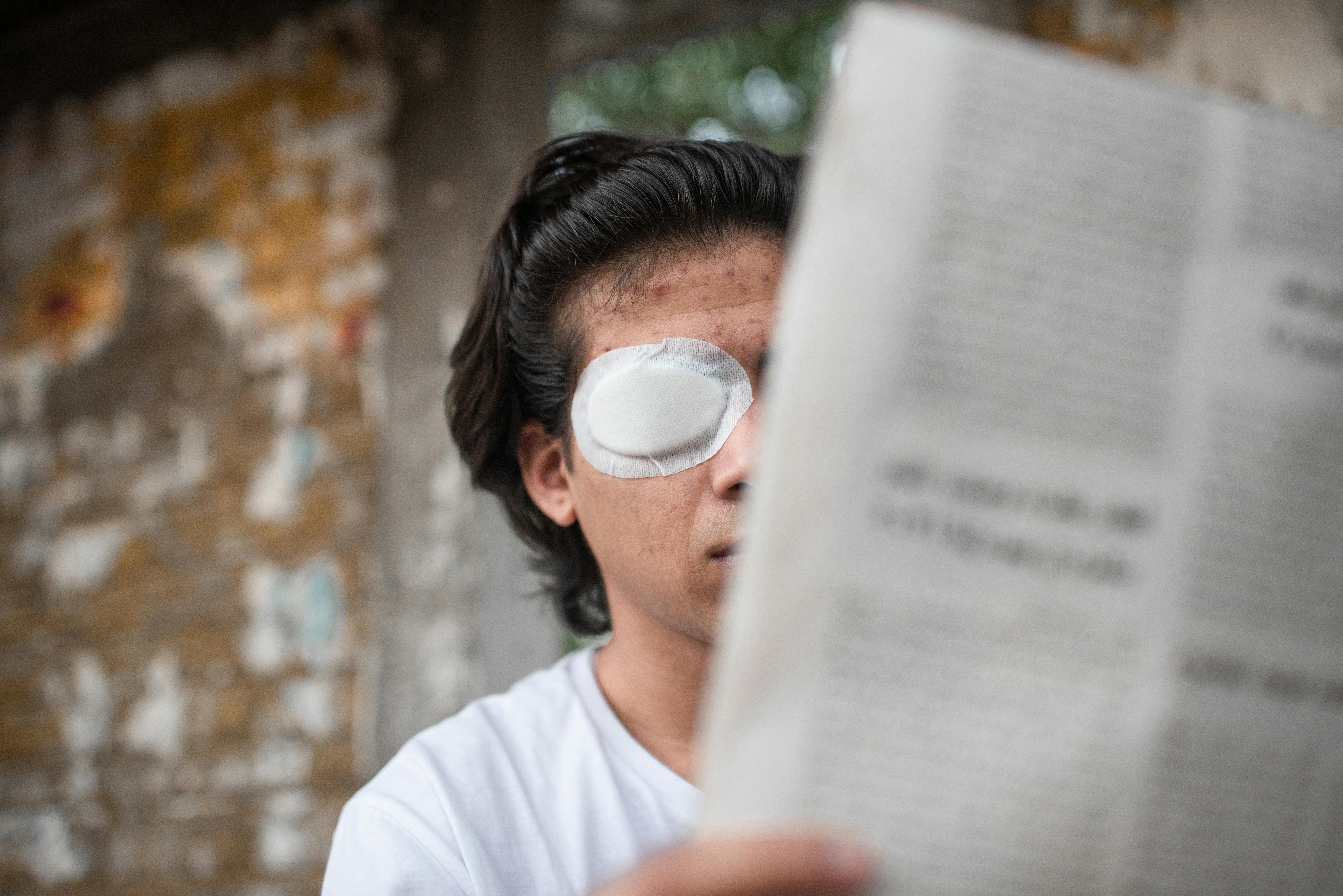 Man with an Eye Patch Reading a Newspaper · Free Stock Photo