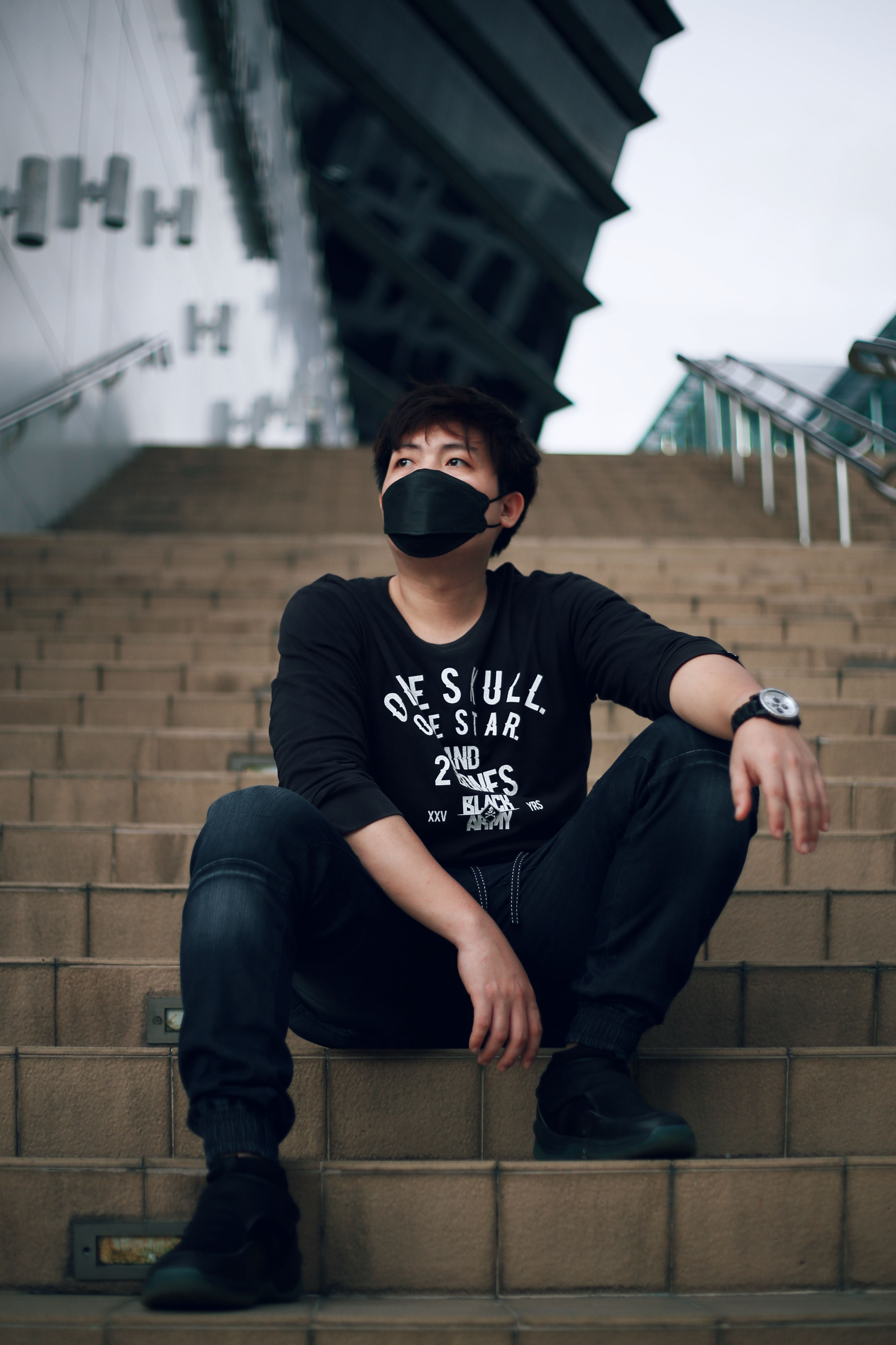 Low-Angle Shot of a Boy Wearing His Face Mask while Sitting on Stairs ...