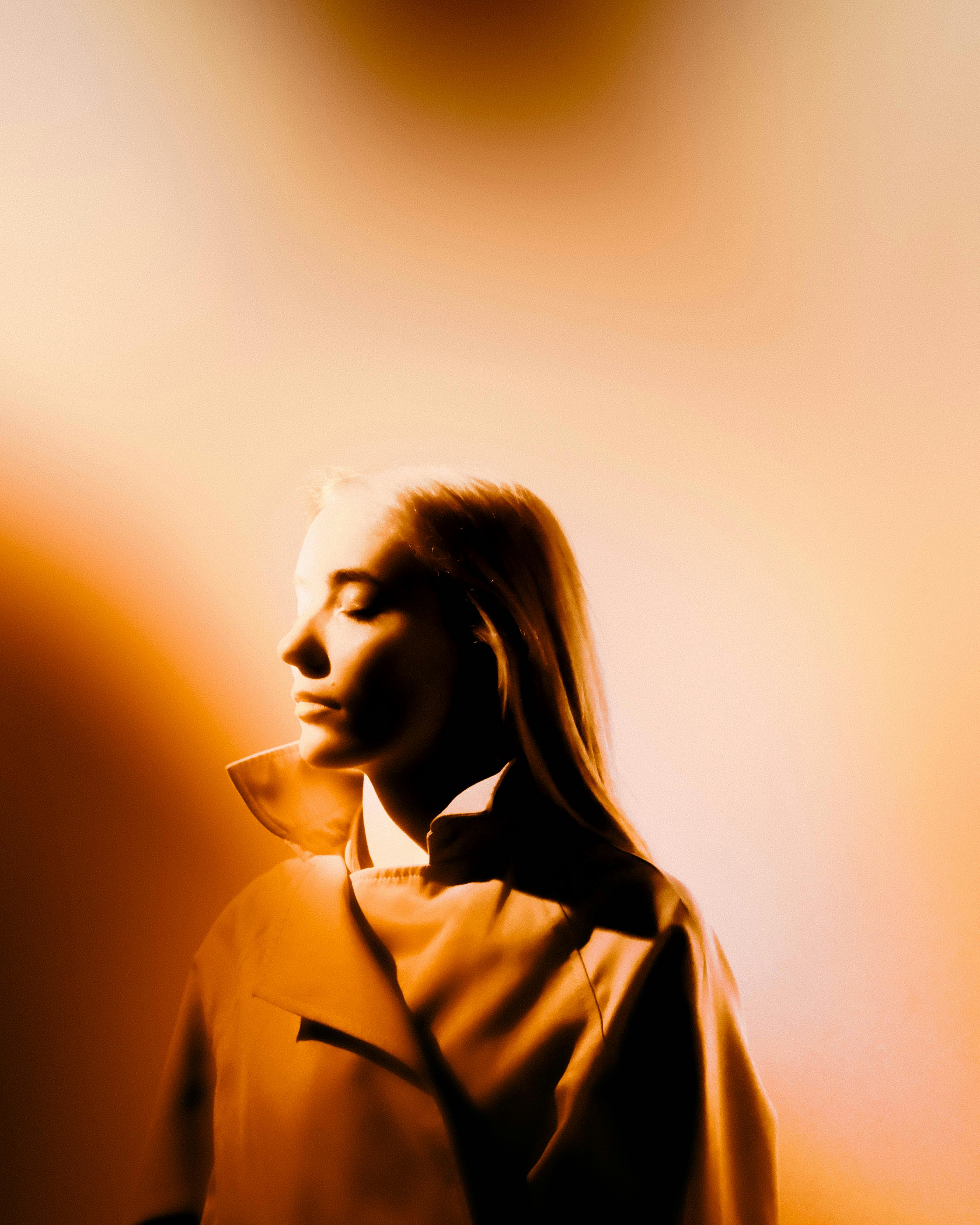 A Woman Lit by a Spotlight in the Dark Room · Free Stock Photo