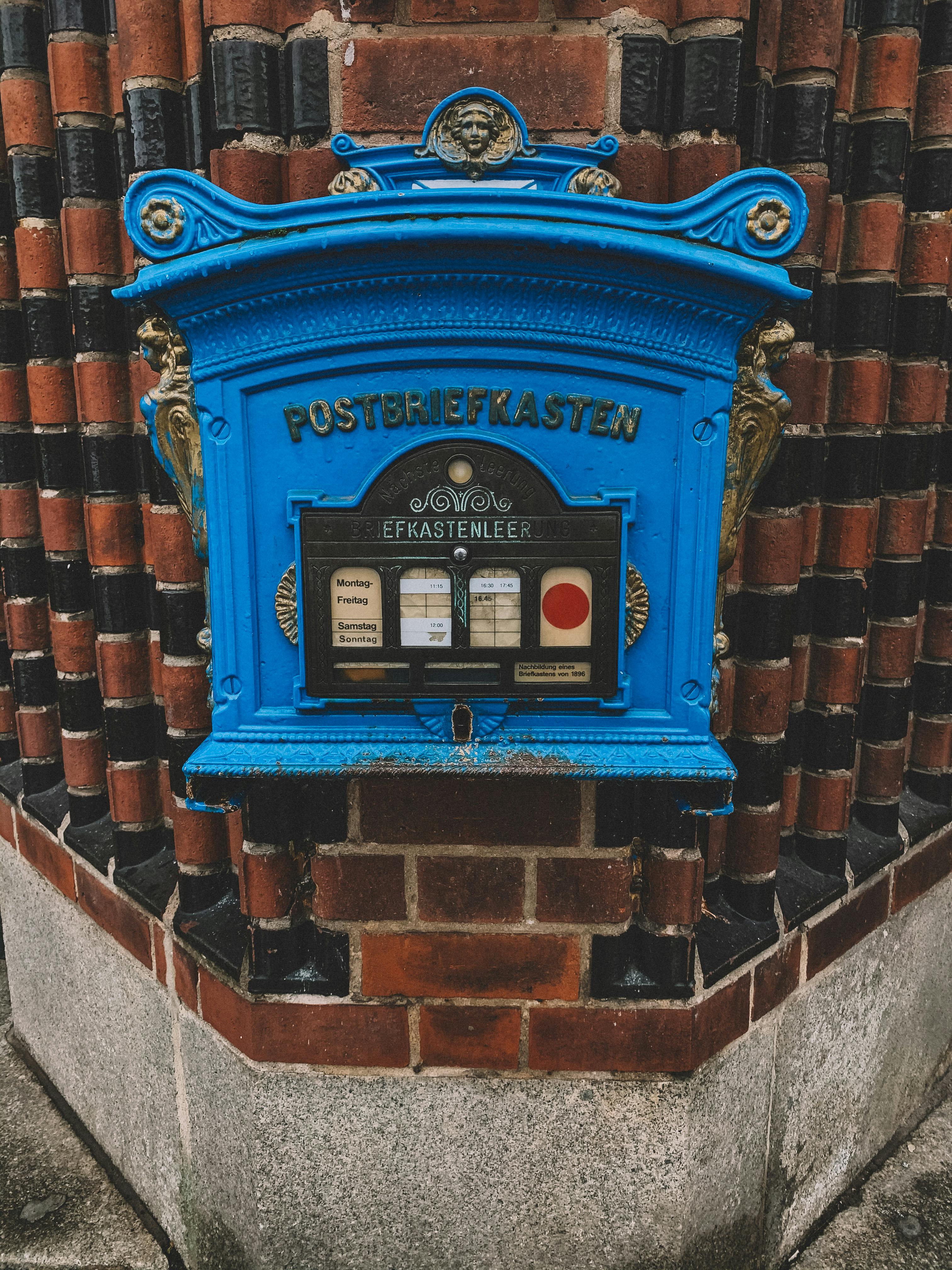 A Blue Post Box on Brown and Black Wall · Free Stock Photo