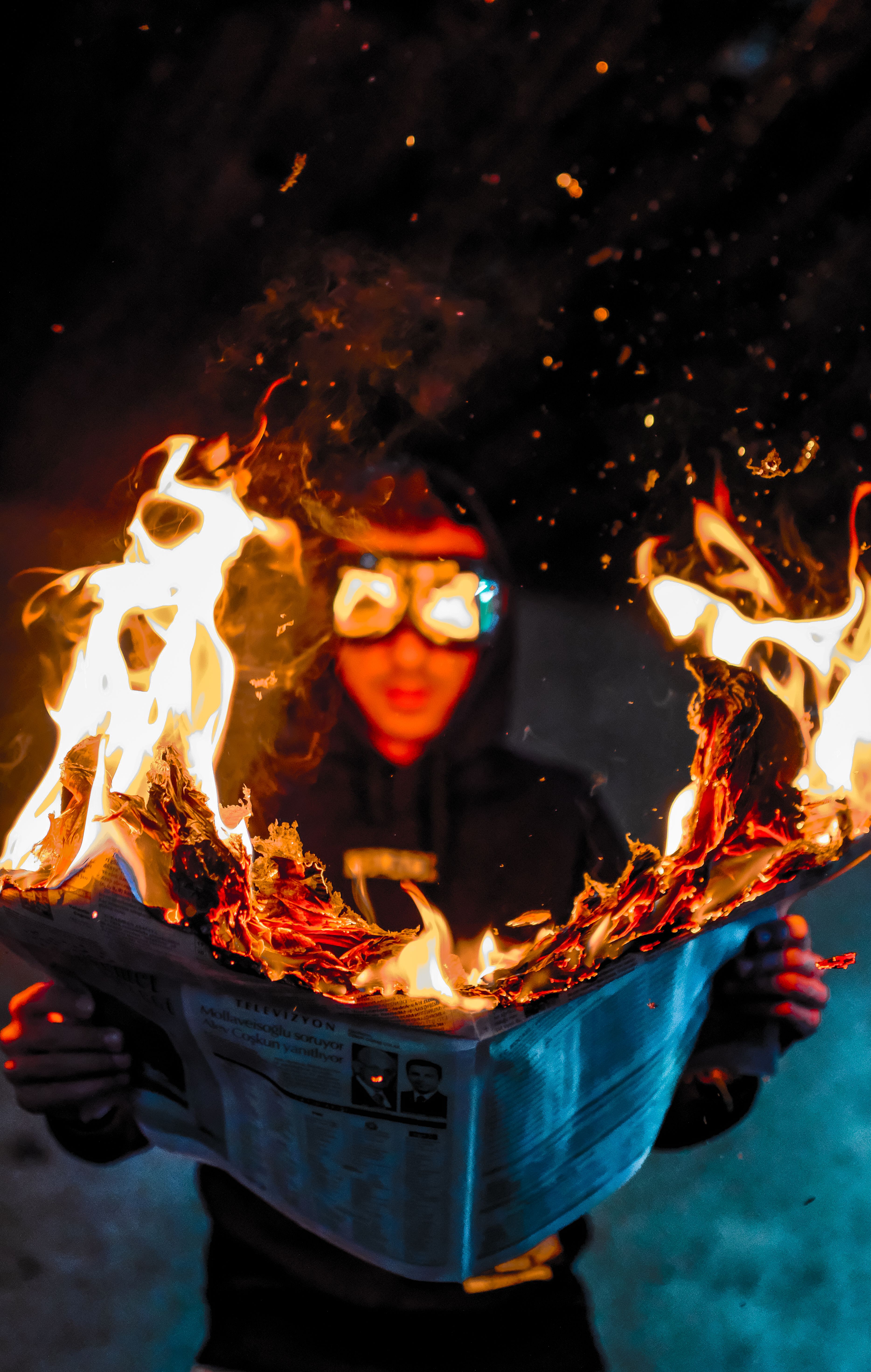 Person in Green Jacket Burning Newspaper · Free Stock Photo
