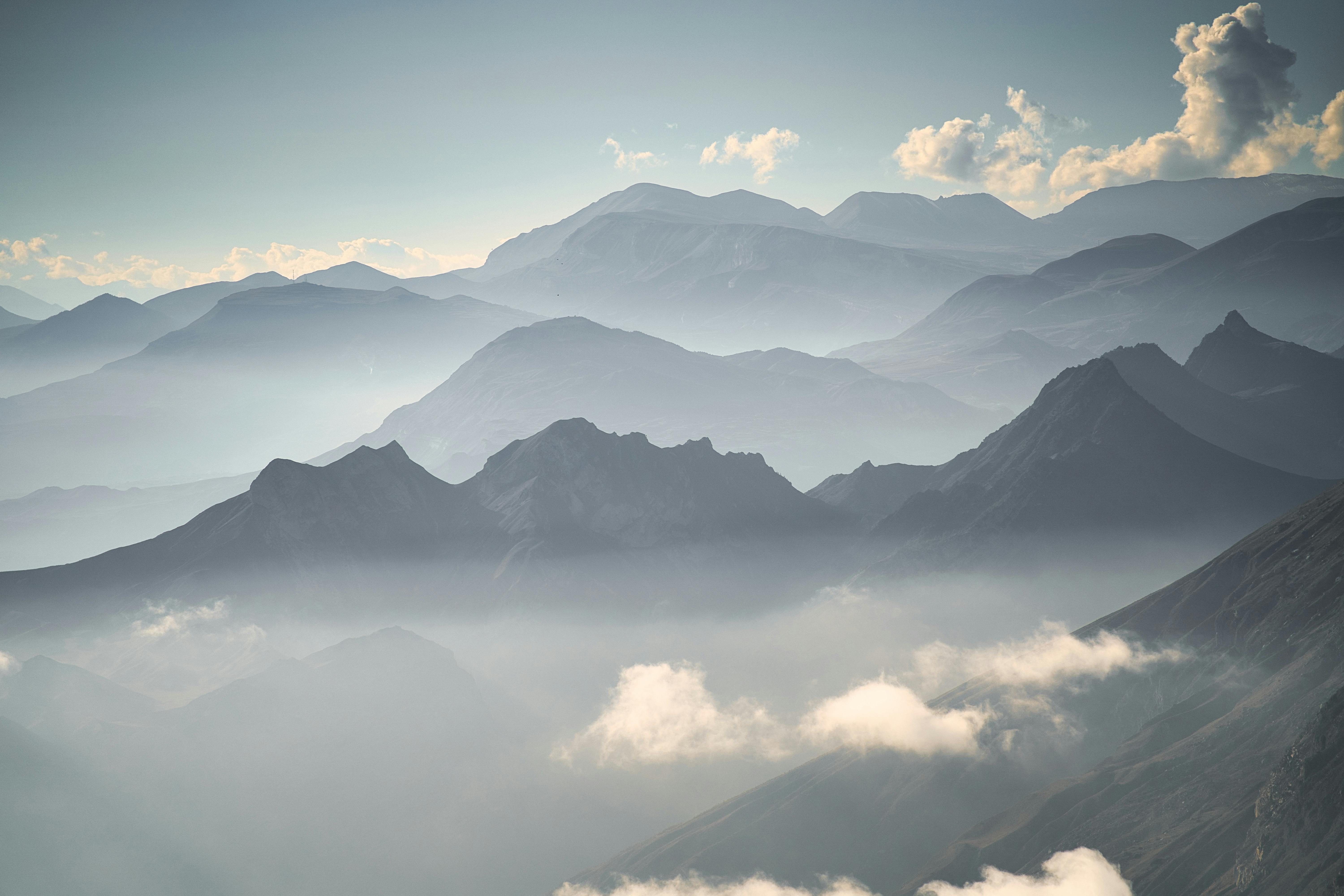 Mountain Ranges Under White Clouds · Free Stock Photo