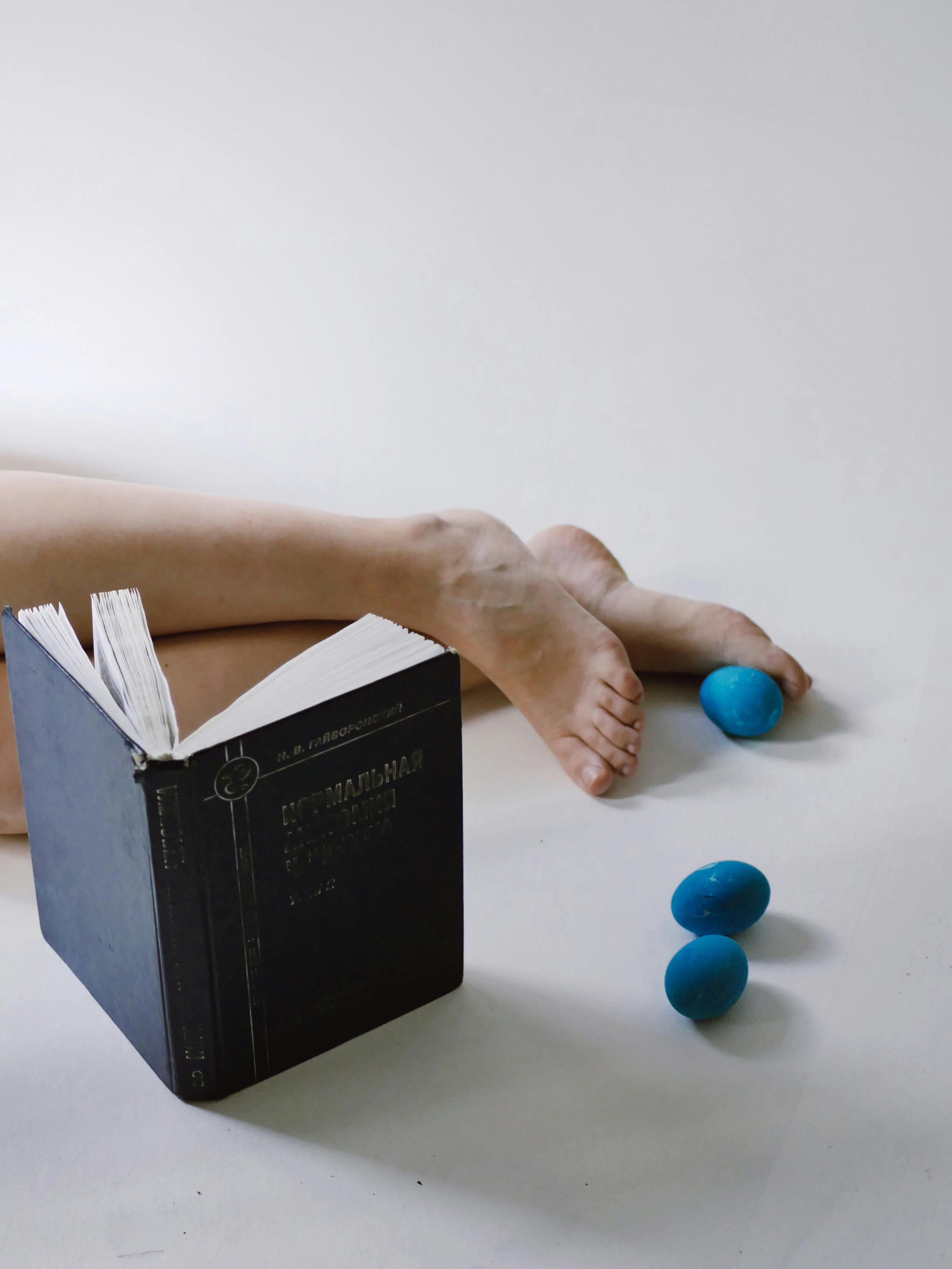 Black Cover Book Near Person's Feet · Free Stock Photo