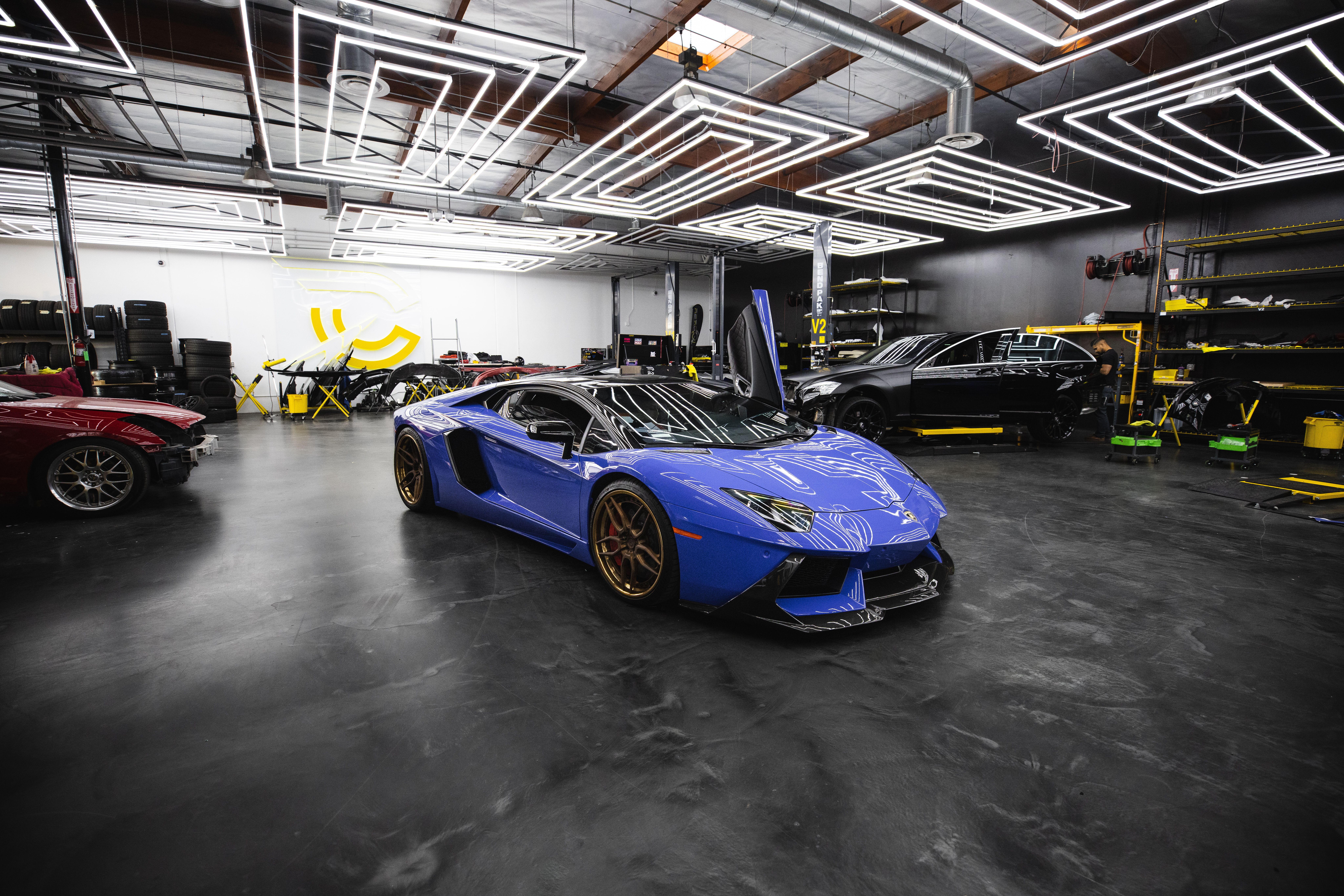 A Shiny Blue Sports Car Parked on Concrete Floor · Free Stock Photo