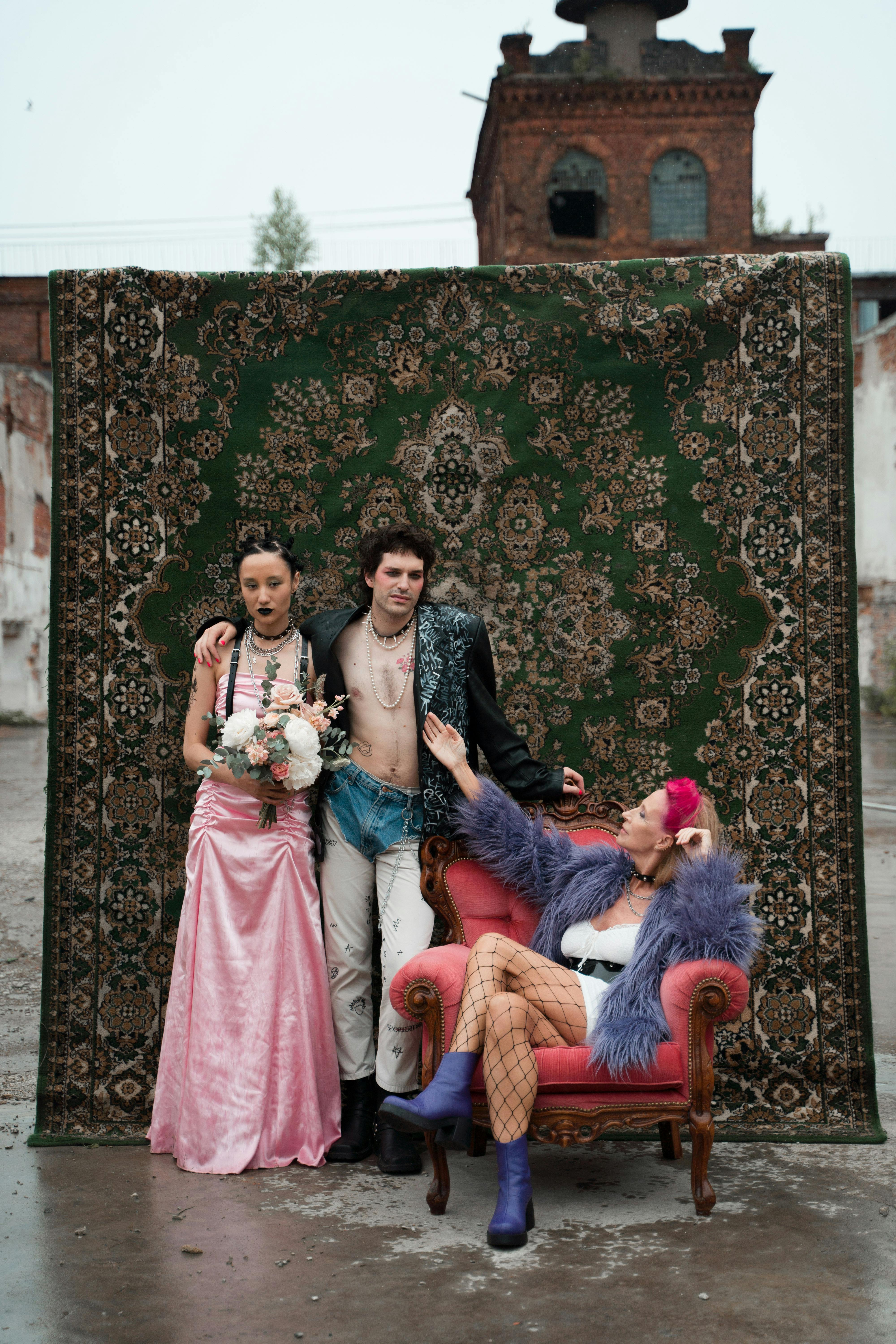 Group of People in Punk Costumes Posing against a Patterned Rug Hanging ...