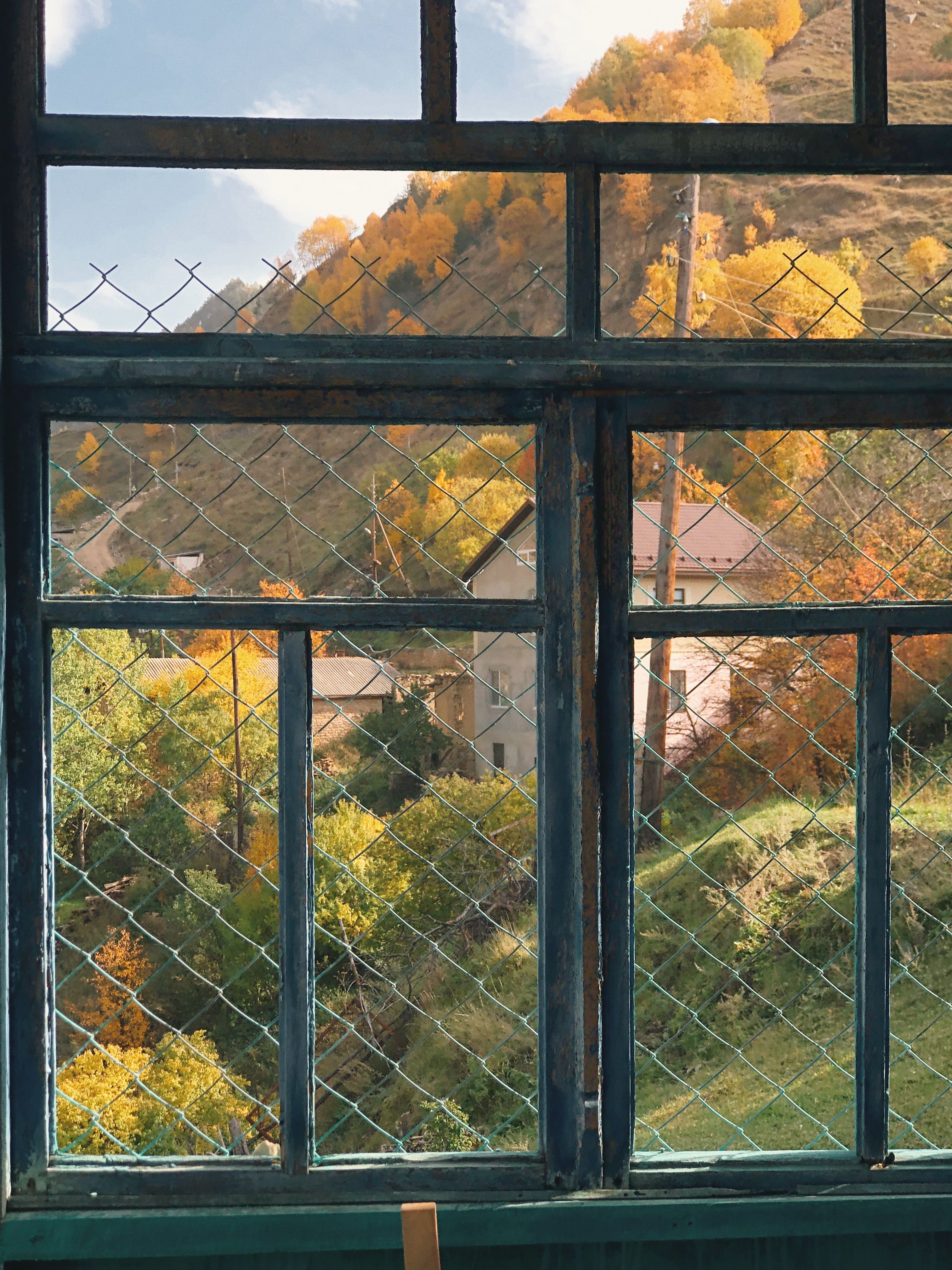 View of Houses on Mountainside from Window Steel Frame with Wire Mesh ...