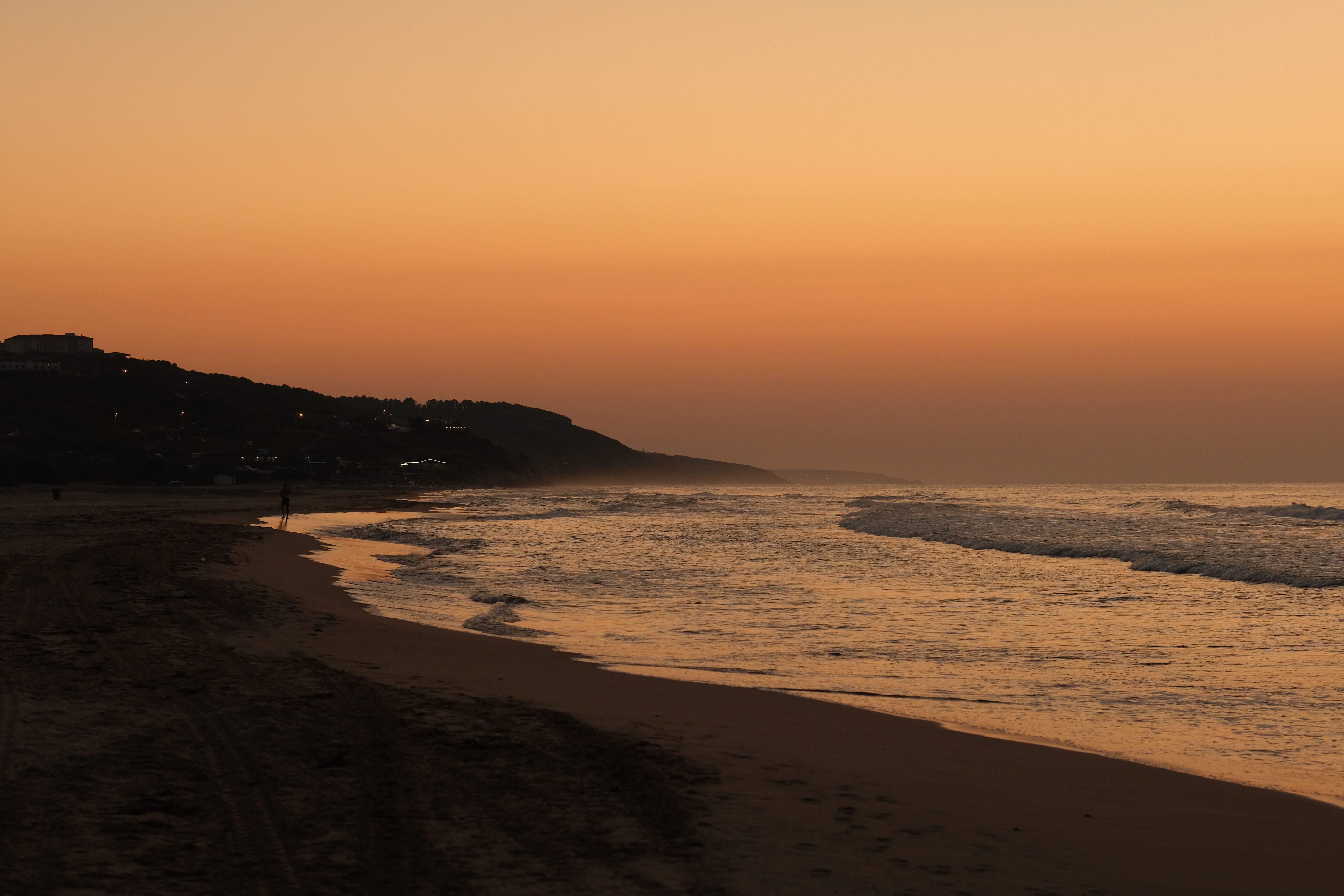 Beautiful Sandy Beach Under Golden Sky · Free Stock Photo