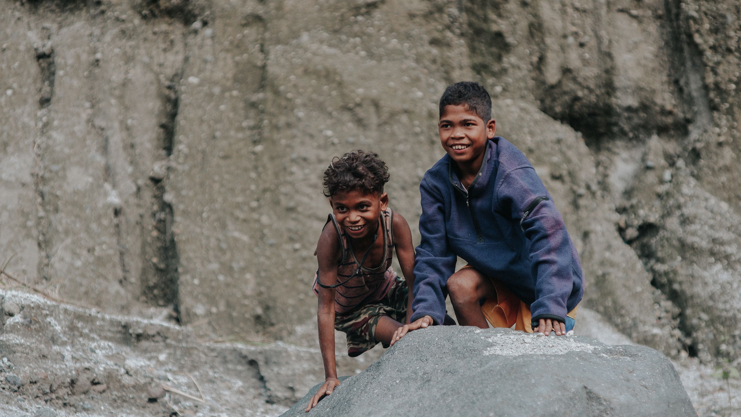 Photograph of Kids Smiling Above a Big Rock · Free Stock Photo