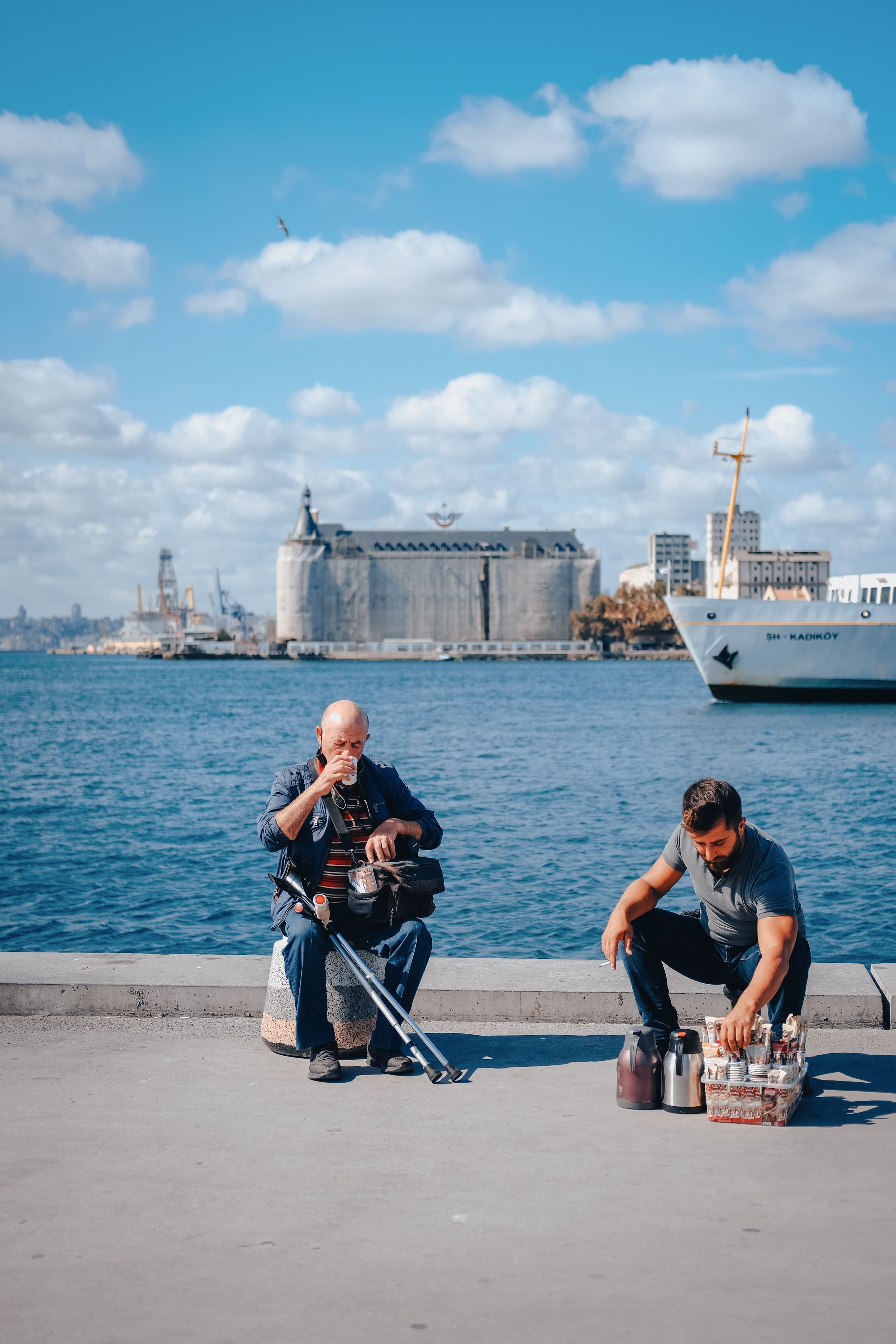Men Sitting on Riverside Drinking Coffee · Free Stock Photo