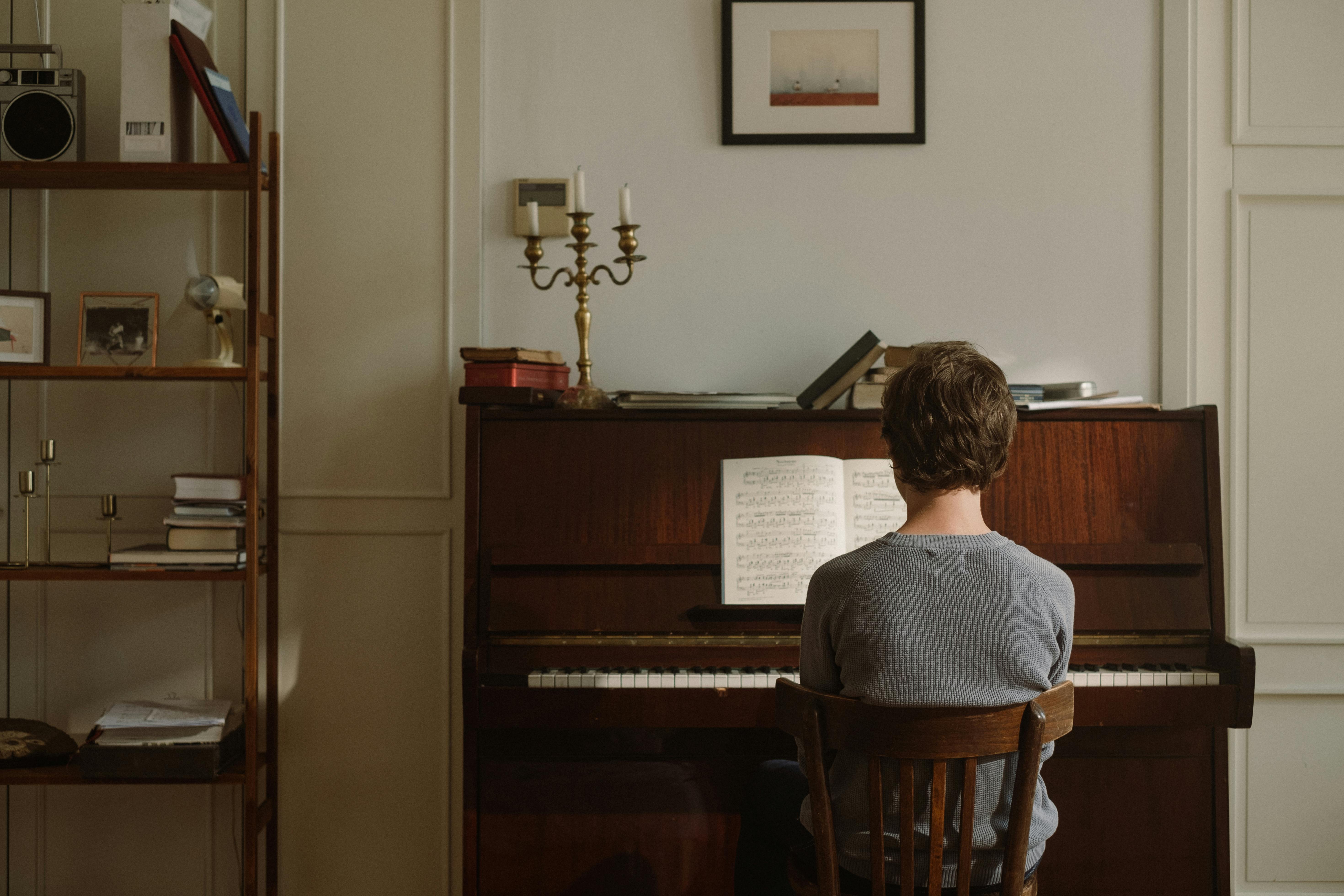 Back View of Person Sitting by the Piano · Free Stock Photo