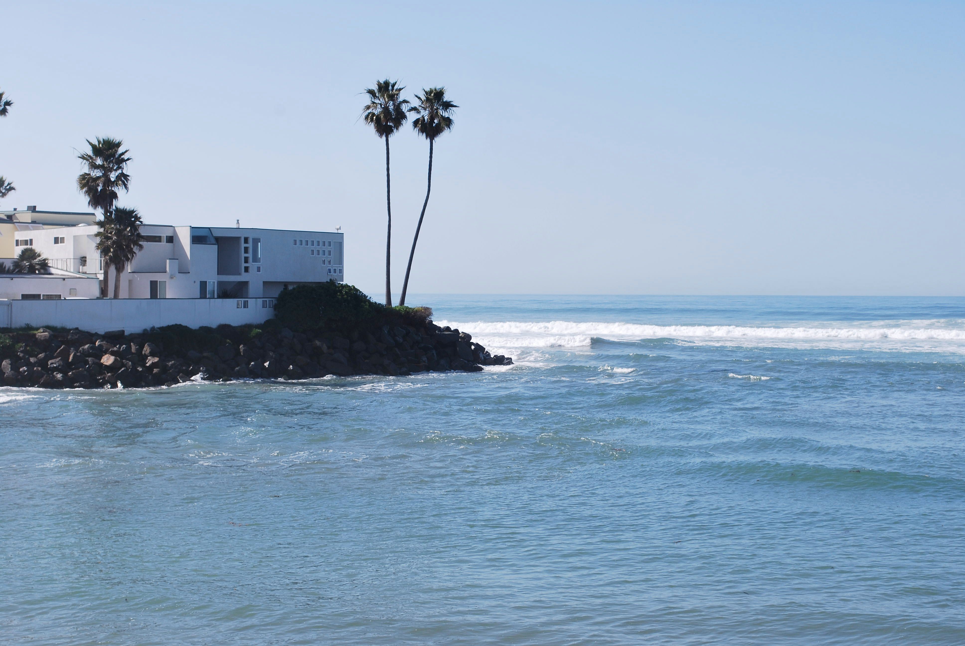 White Concrete Building Beside the Sea · Free Stock Photo