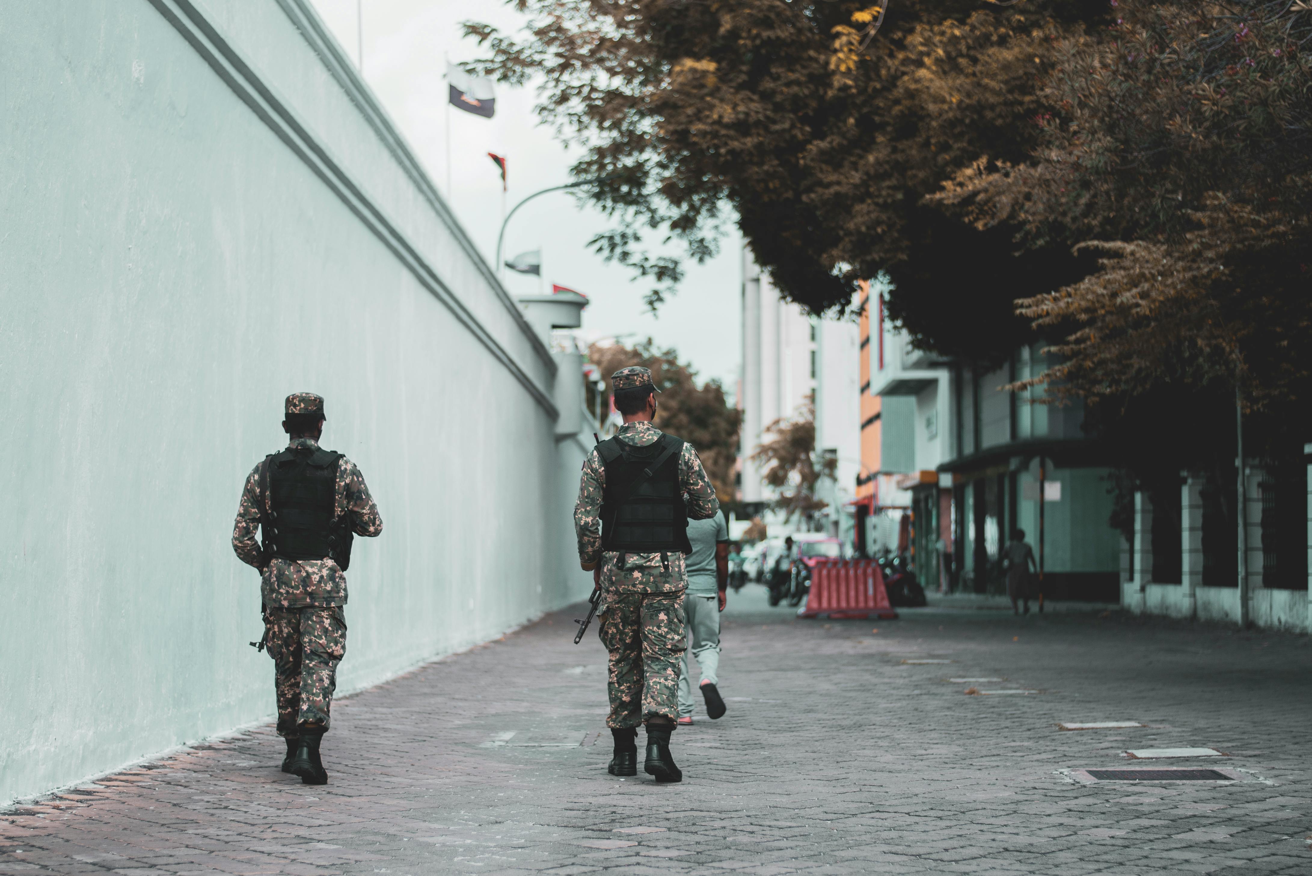 A Back View of a Two Military Walking on the Street · Free Stock Photo