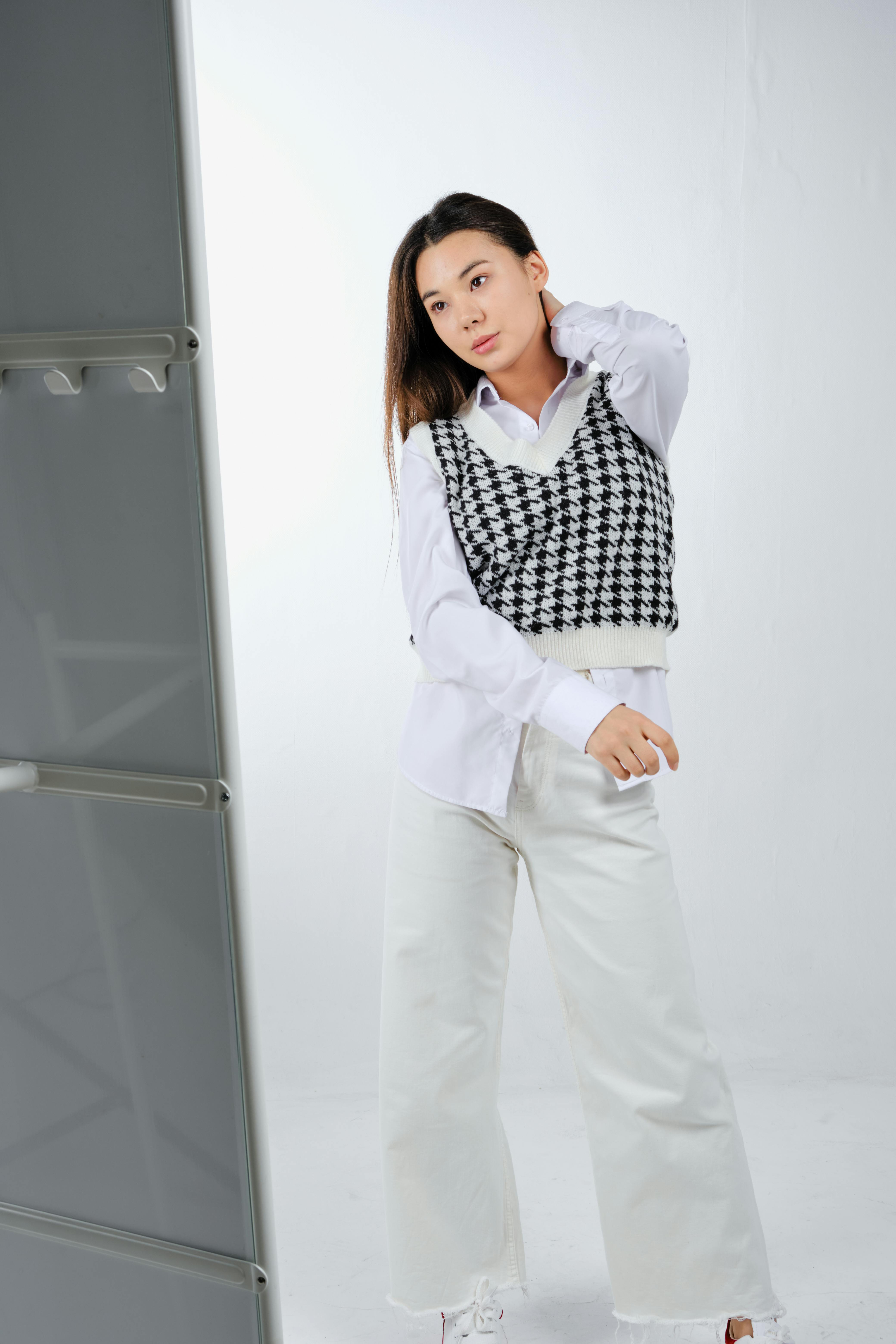 Woman in a Knitted Vest Posing with Her Hand on Her Neck · Free Stock Photo