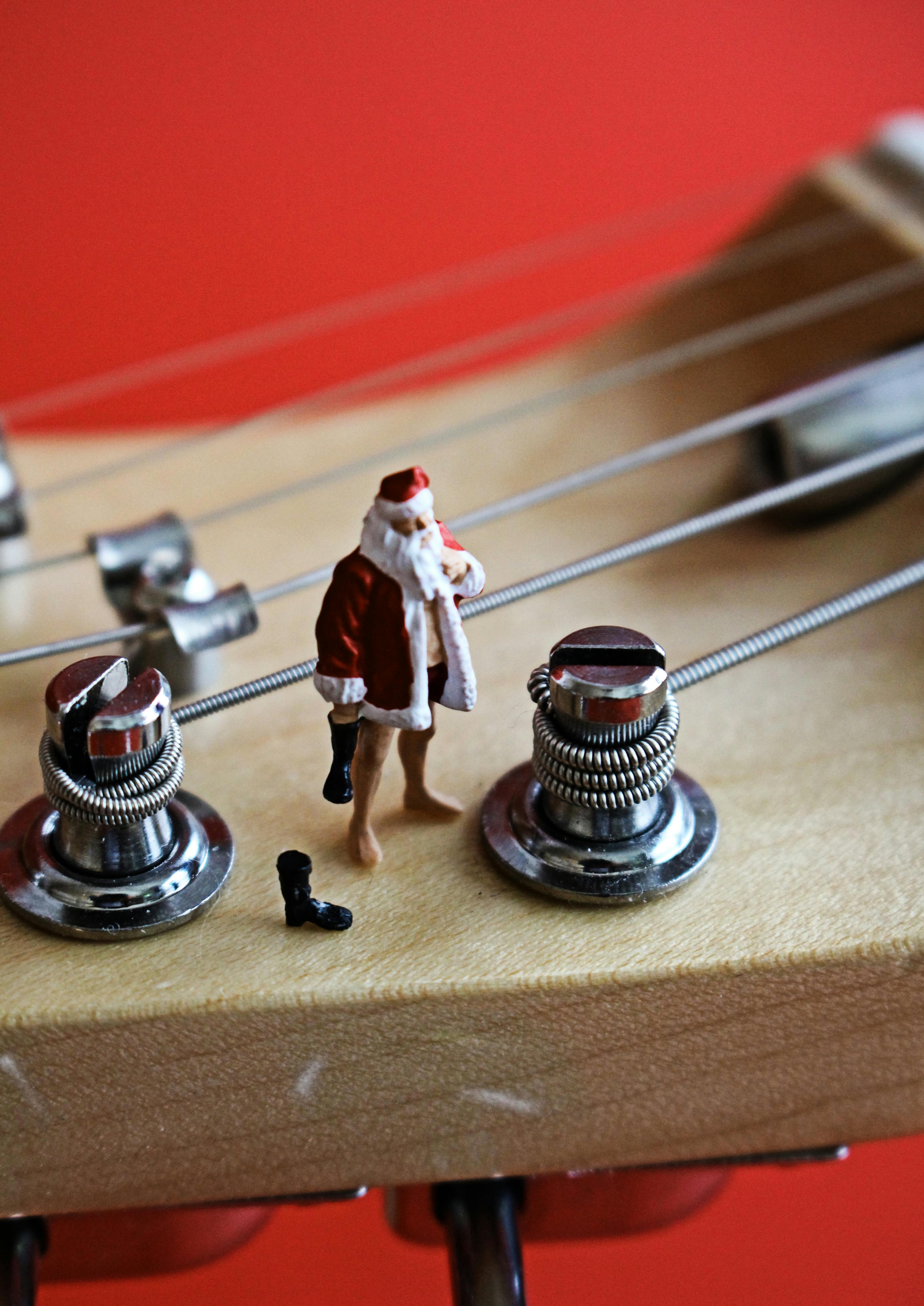 Close-Up Photo of a Miniature Santa Claus Beside Guitar Strings · Free ...