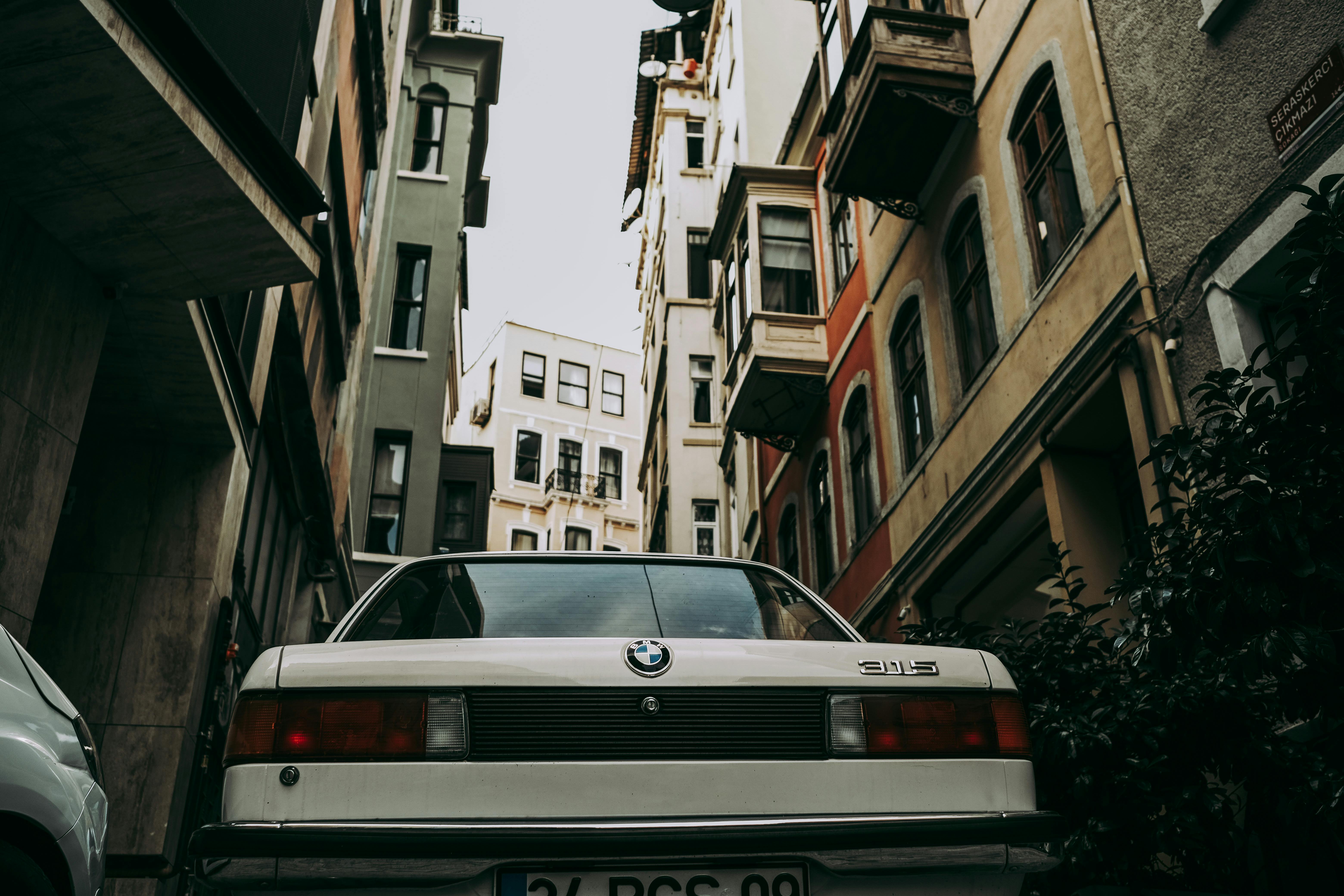 White Car Parked Between Apartment Buildings · Free Stock Photo